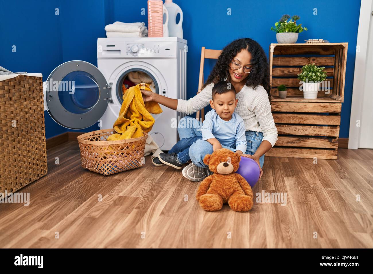 Mother and son smiling confident washing clothes at laundry room Stock ...