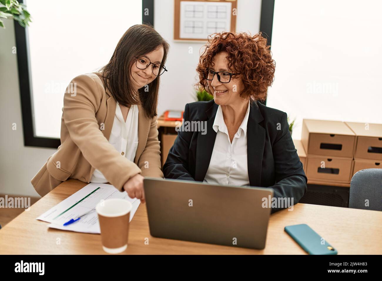 Group of two women working at the office. Mature woman and down ...