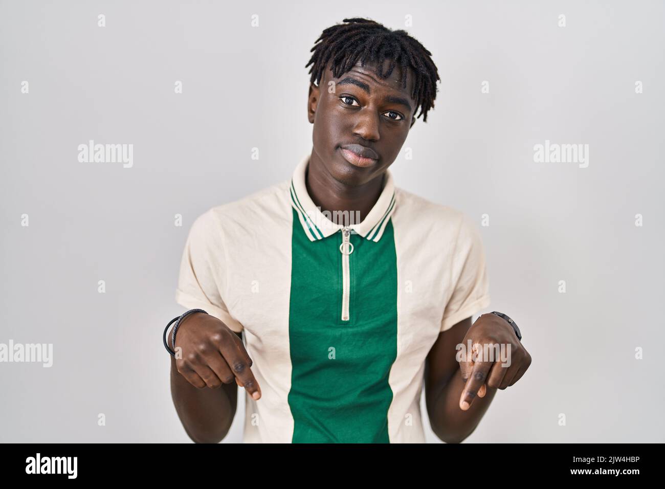 African man with dreadlocks standing over isolated background pointing ...
