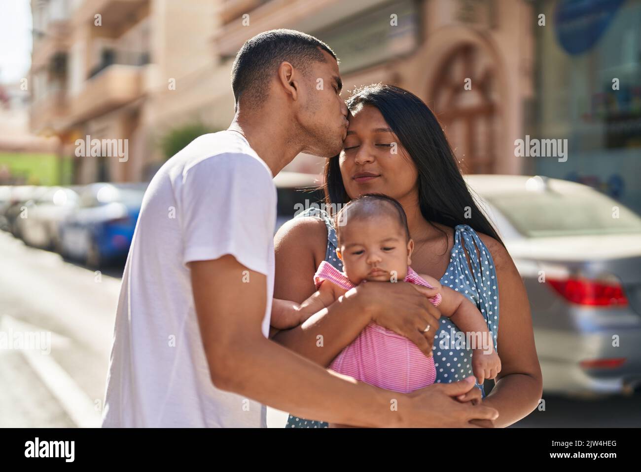 Hispanic family hugging each other kissing at street Stock Photo - Alamy