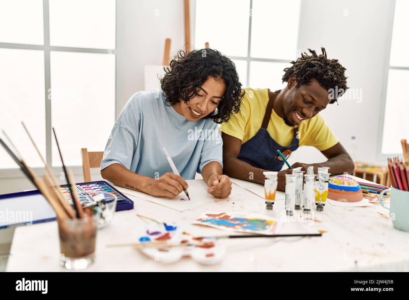 African american artist couple smiling happy painting sitting on the ...