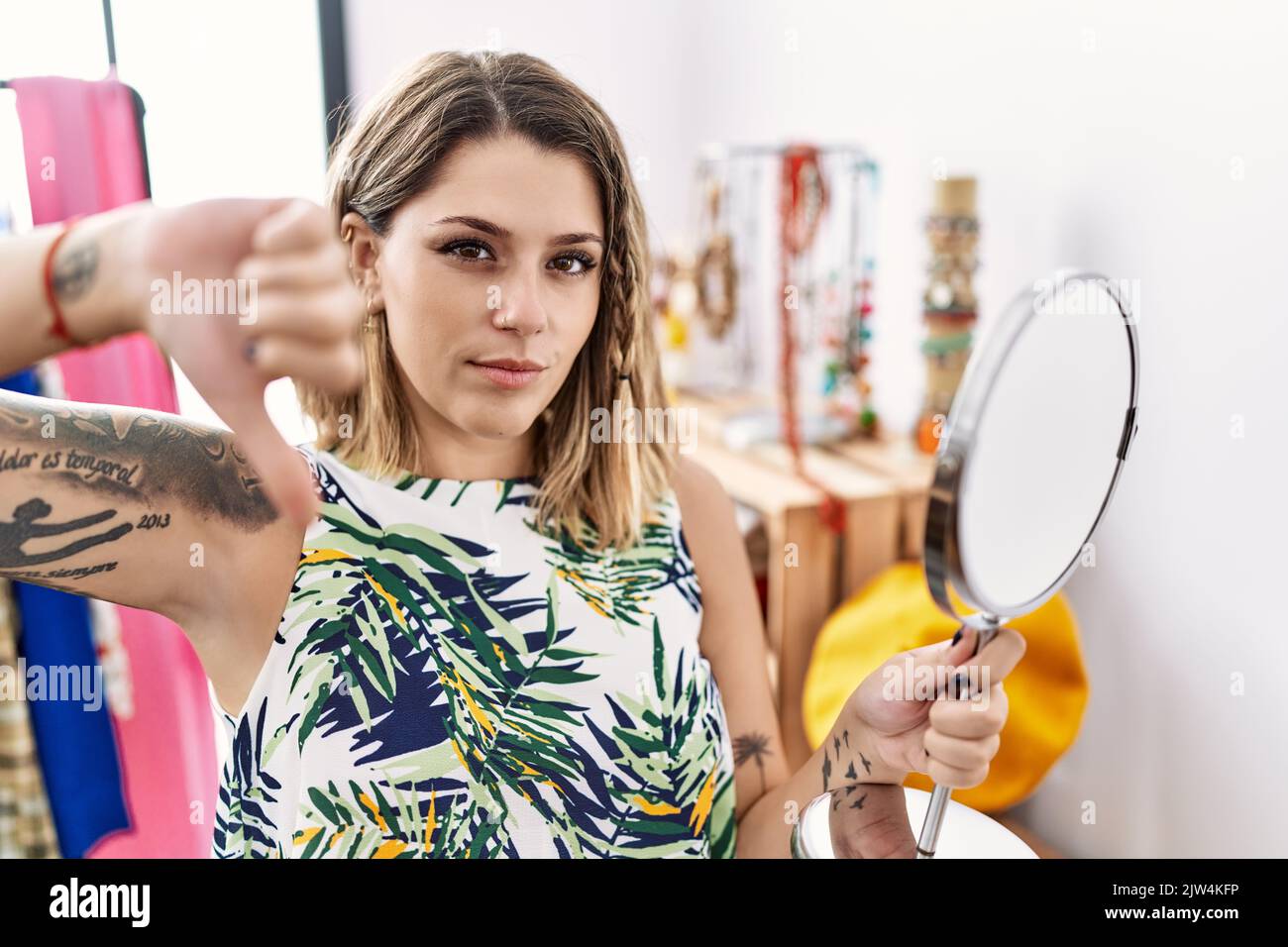 Young hispanic customer woman looking earrings on the mirror at store ...