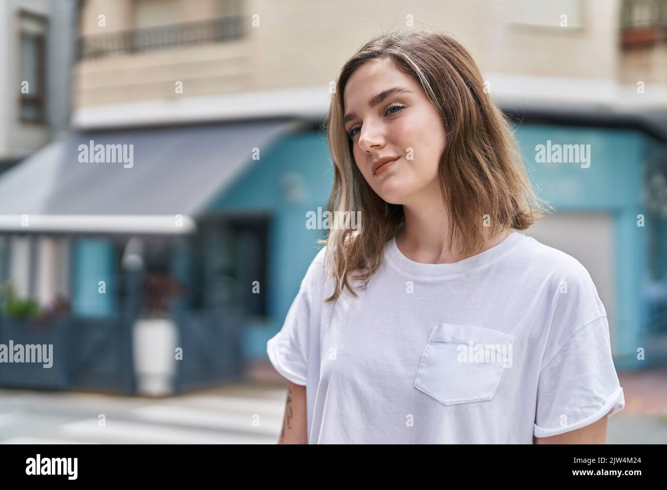 Young woman with relaxed expression standing at street Stock Photo - Alamy