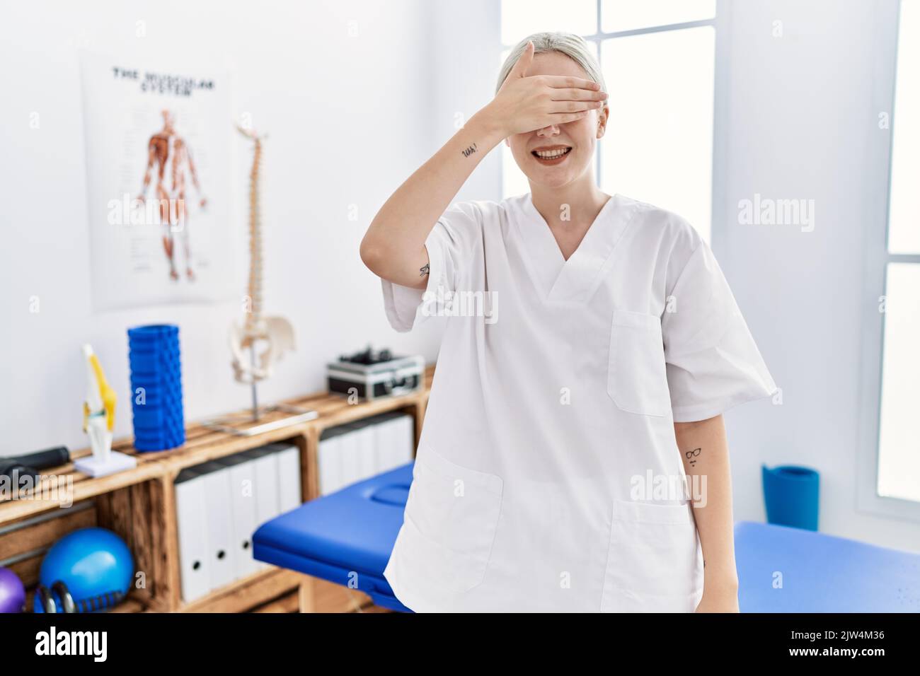 Young caucasian woman working at pain recovery clinic smiling and ...