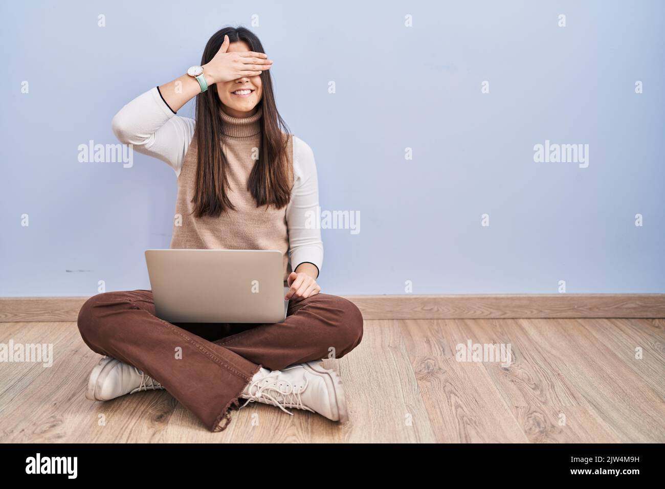 Young brunette woman working using computer laptop sitting on the floor ...