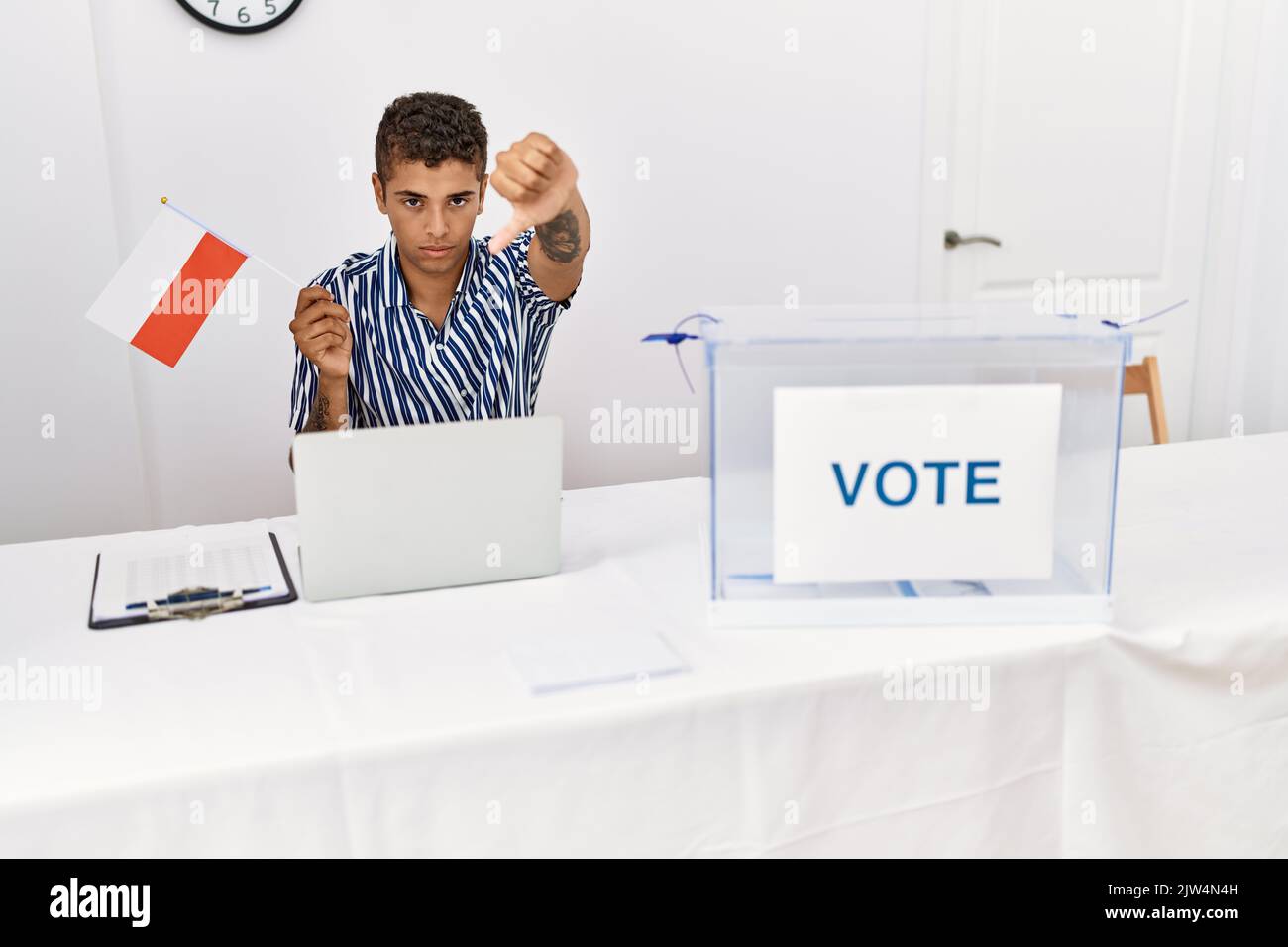 Young handsome hispanic man at political campaign election holding ...