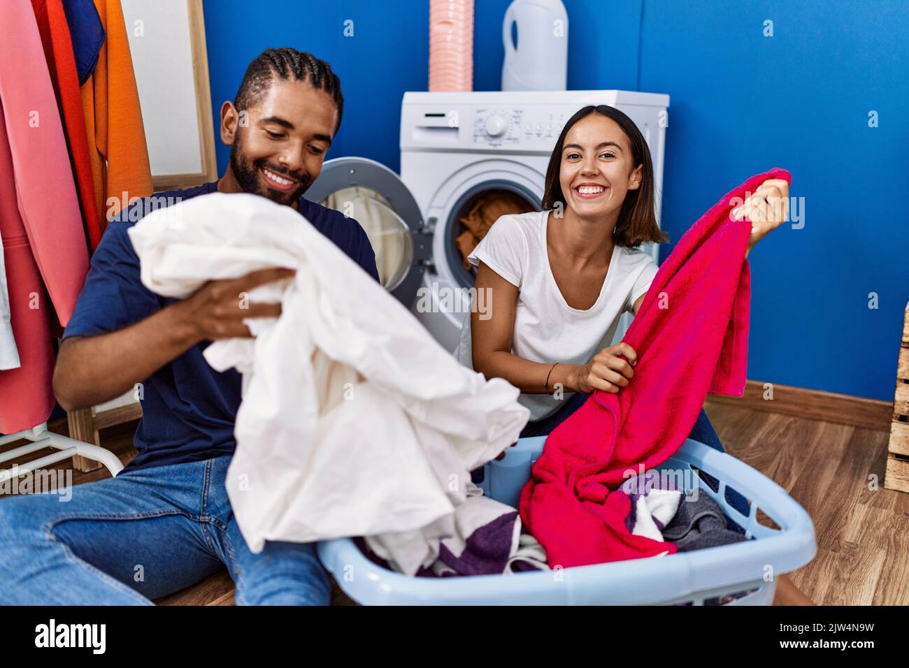 Man and woman couple smiling confident washing clothes at laundry Stock ...