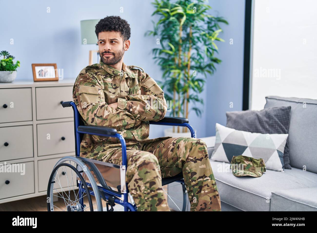 Arab man wearing camouflage army uniform sitting on wheelchair smiling ...