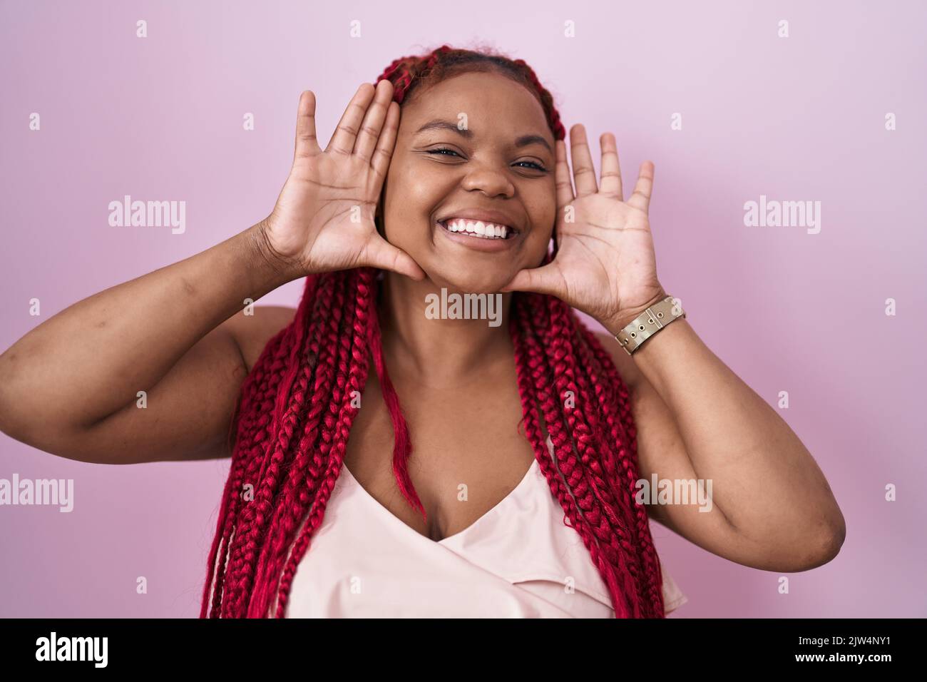 African american woman with braided hair standing over pink background ...