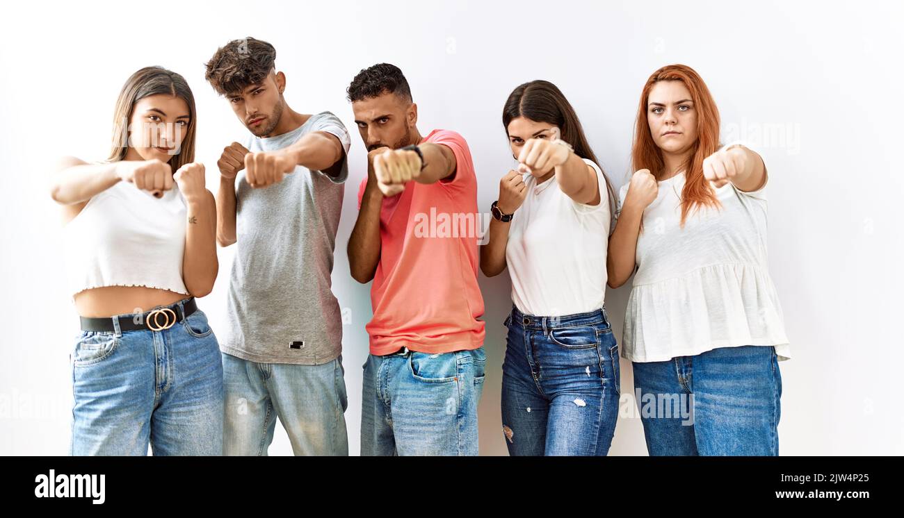 Group of young friends standing together over isolated background ...