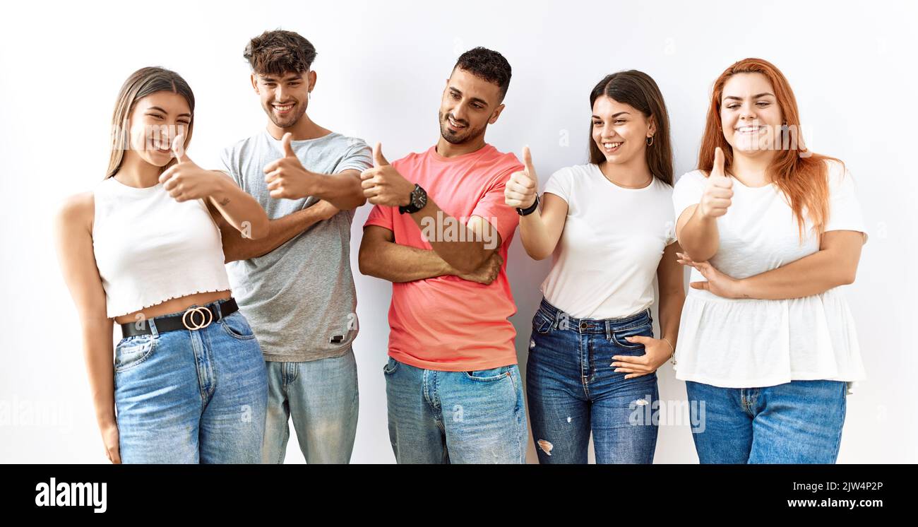 Group of young friends standing together over isolated background ...