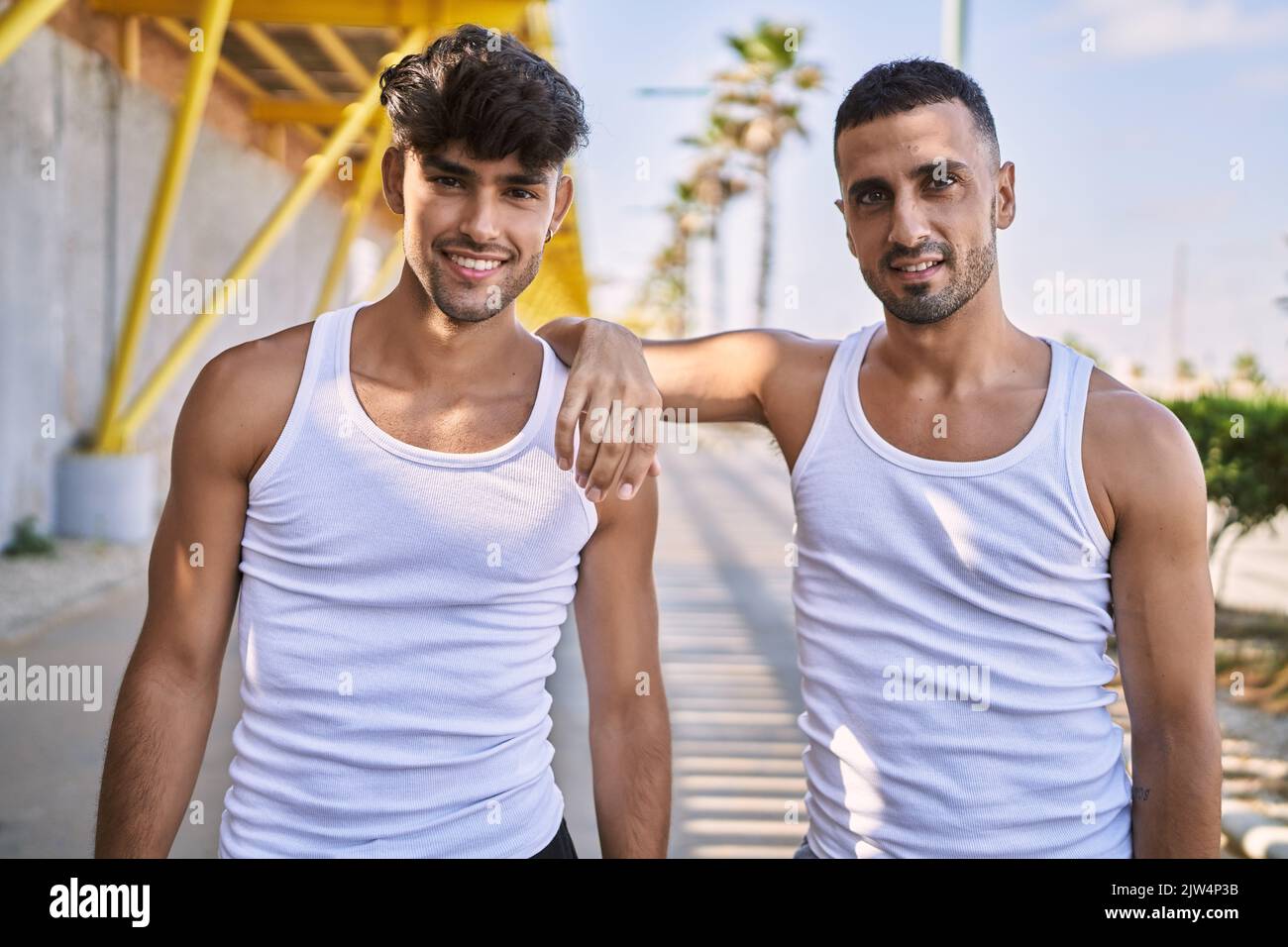 Two hispanic men sporty couple smiling confident standing at street ...
