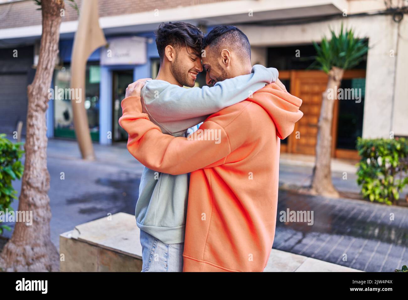 Two man couple hugging each other standing at street Stock Photo - Alamy