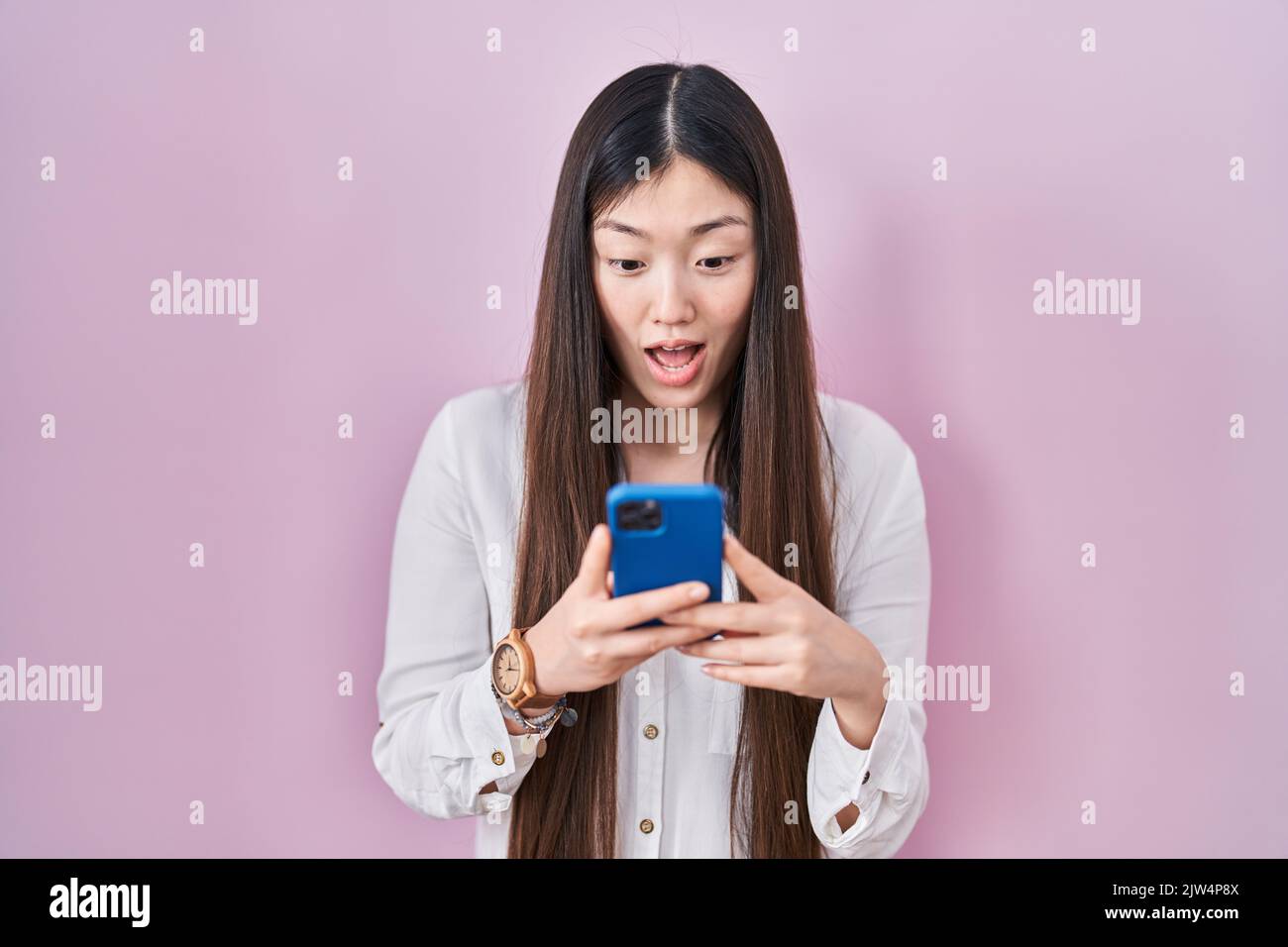 Chinese young woman using smartphone typing message celebrating crazy ...