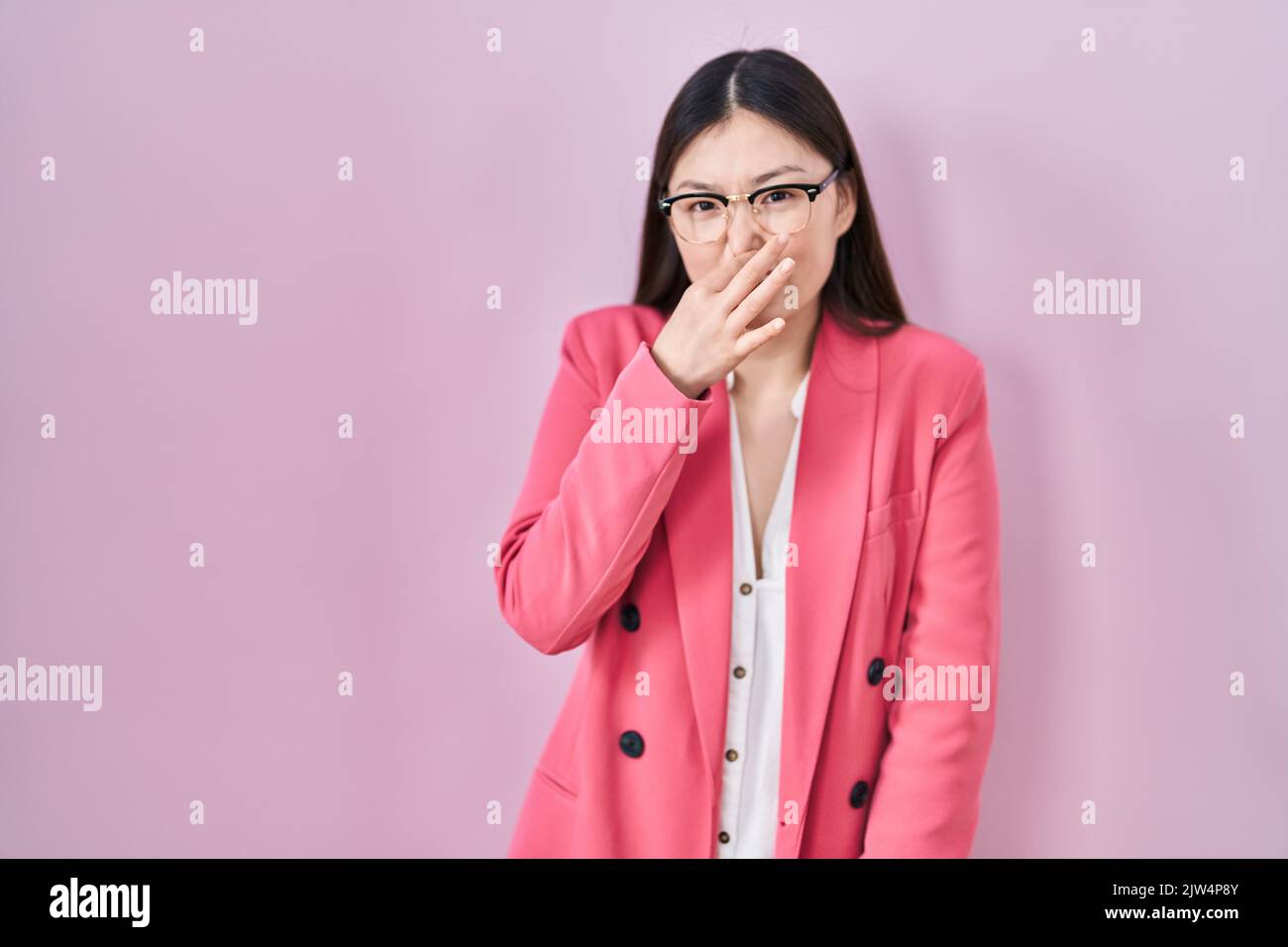 Chinese business young woman wearing glasses smelling something stinky ...