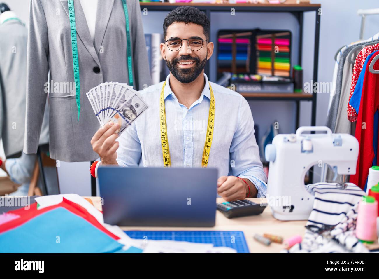 Hispanic man with beard dressmaker designer holding dollars looking ...