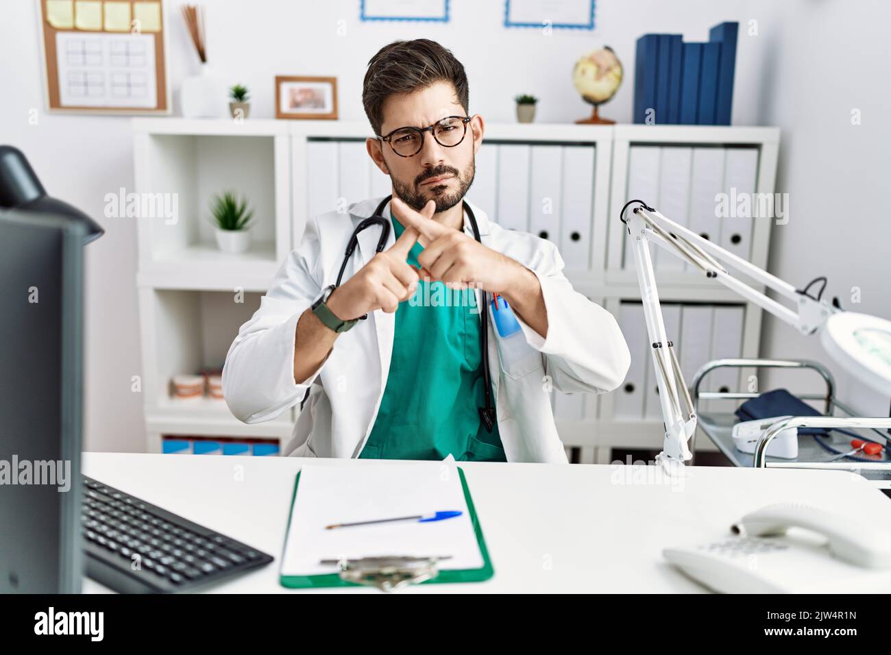 Young man with beard wearing doctor uniform and stethoscope at the ...