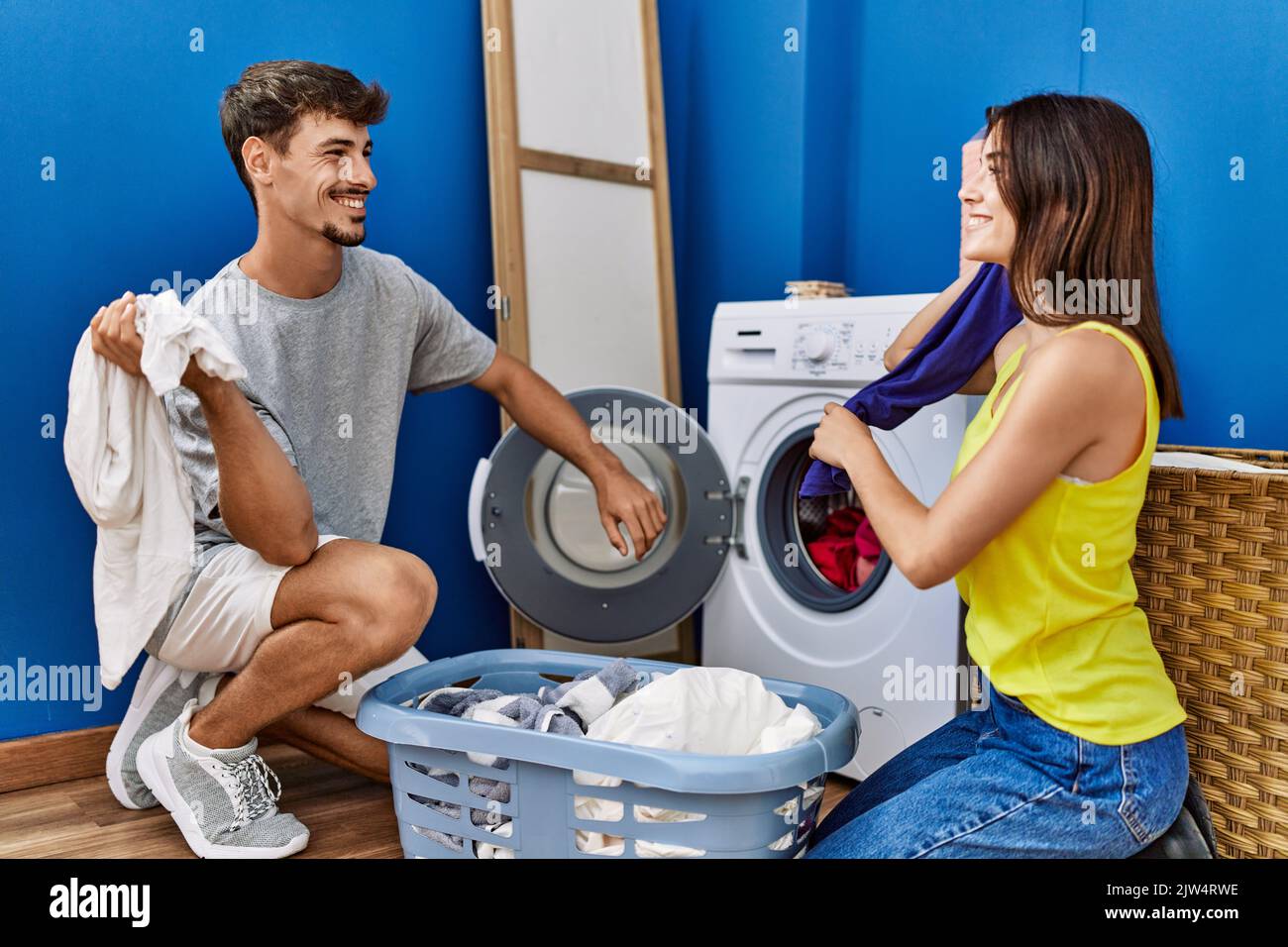 Man and woman couple fighting and washing clothes at laundry room Stock ...