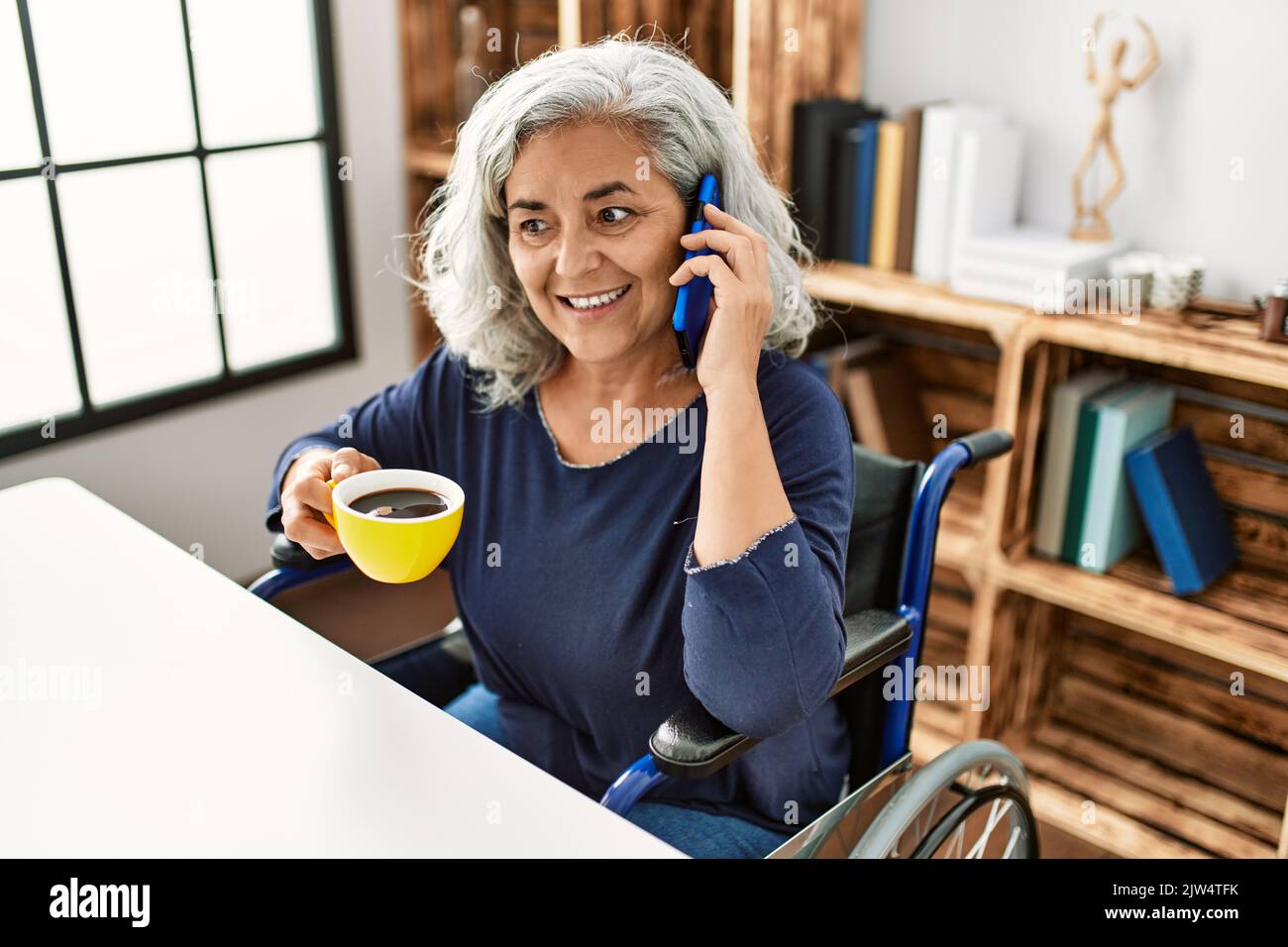 Middle age grey-haired disabled woman talking on the smartphone and ...