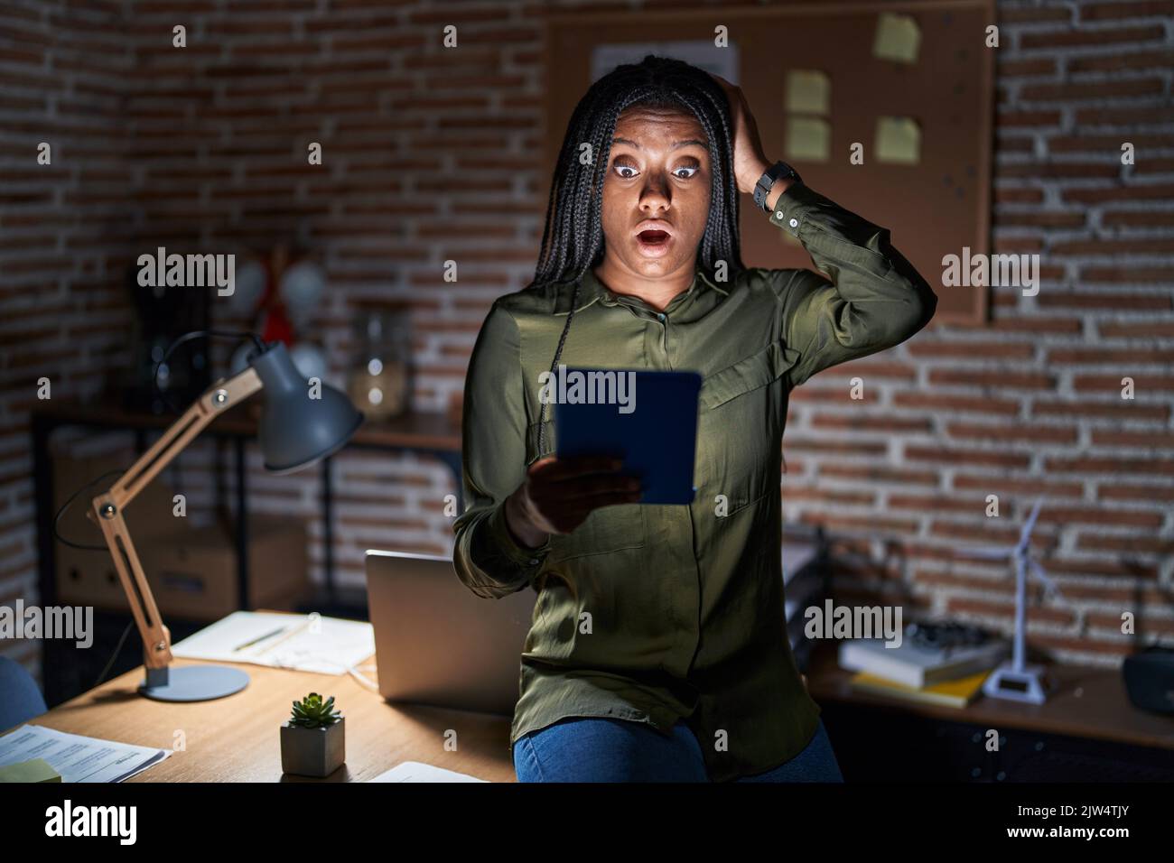 Young african american with braids working at the office at night crazy ...