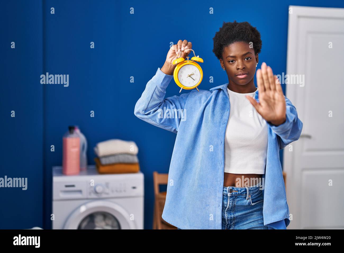 African american woman waiting for laundry with open hand doing stop ...