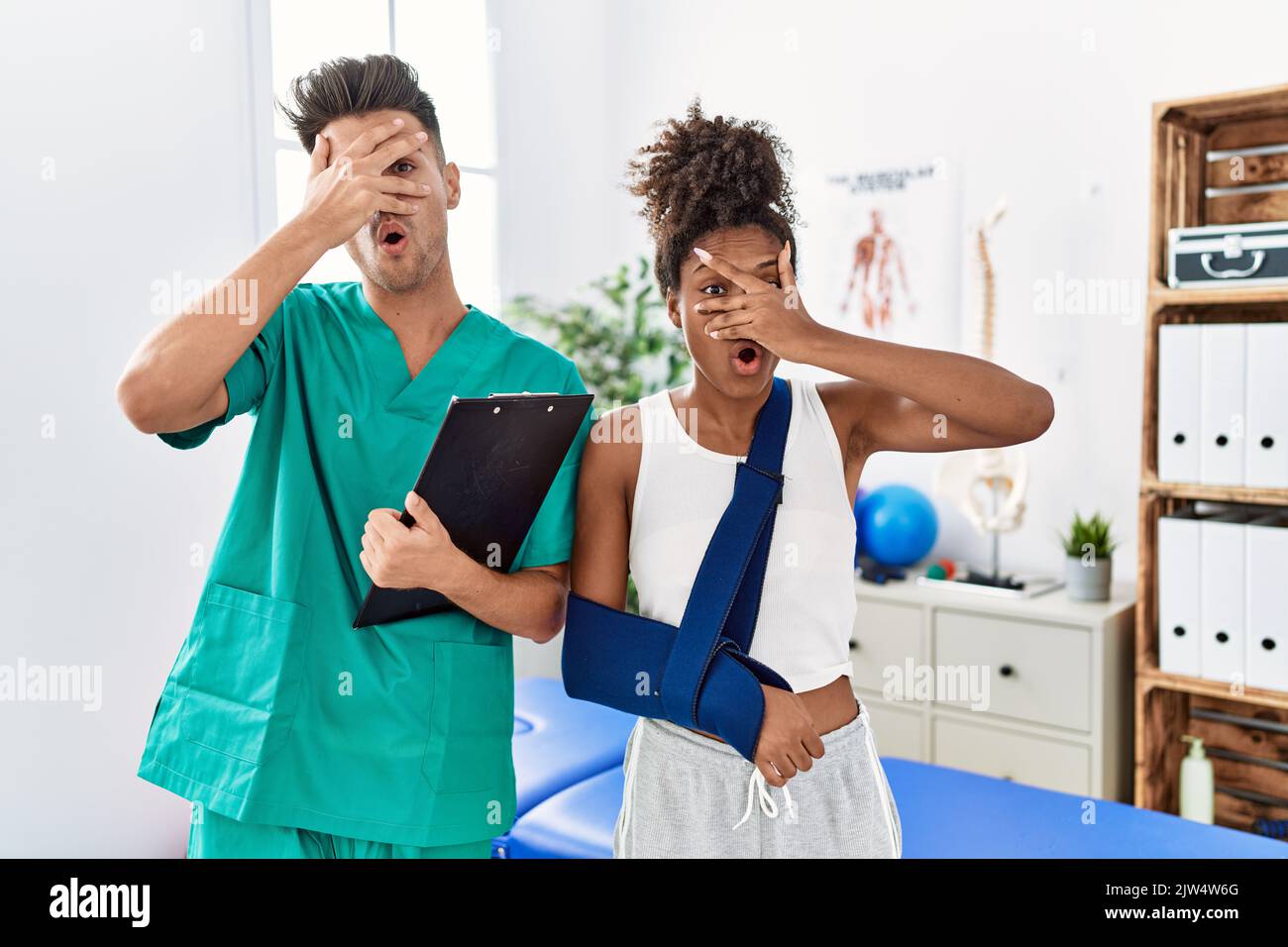 Physiotherapist working with patient wearing arm on sling at ...