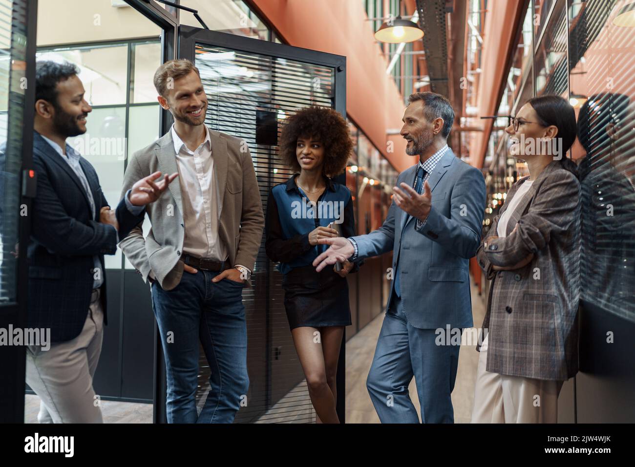 Multiethnic group of business people talking in office during break ...