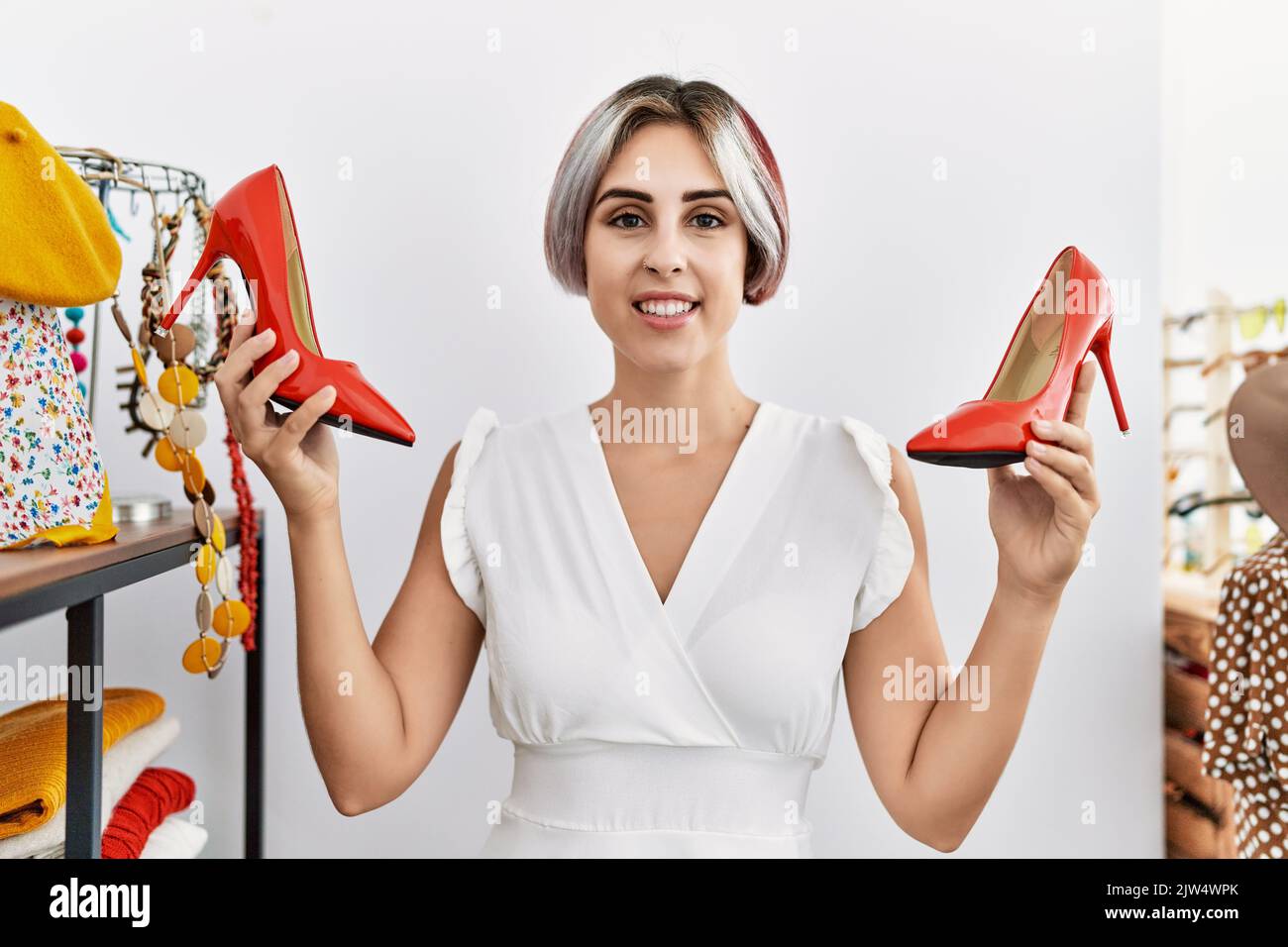 Young caucasian customer woman smiling happy choosing high heel shoes ...