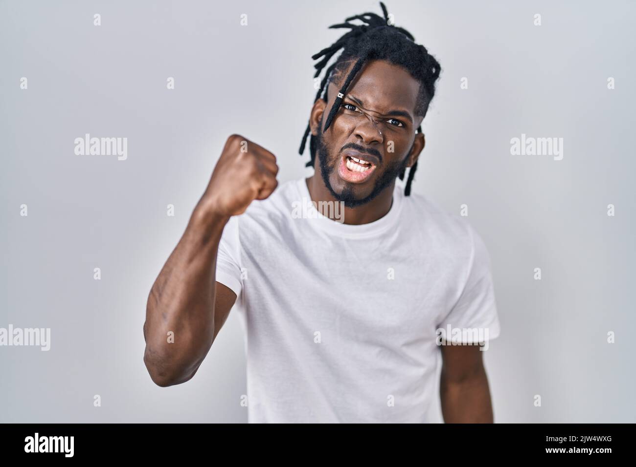 African man with dreadlocks wearing casual t shirt over white ...