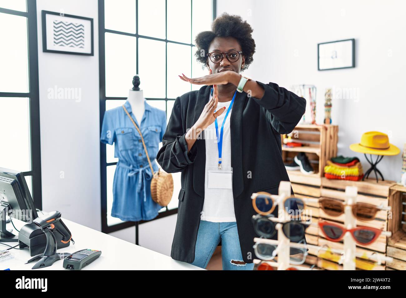 African young woman working as manager at retail boutique doing time ...