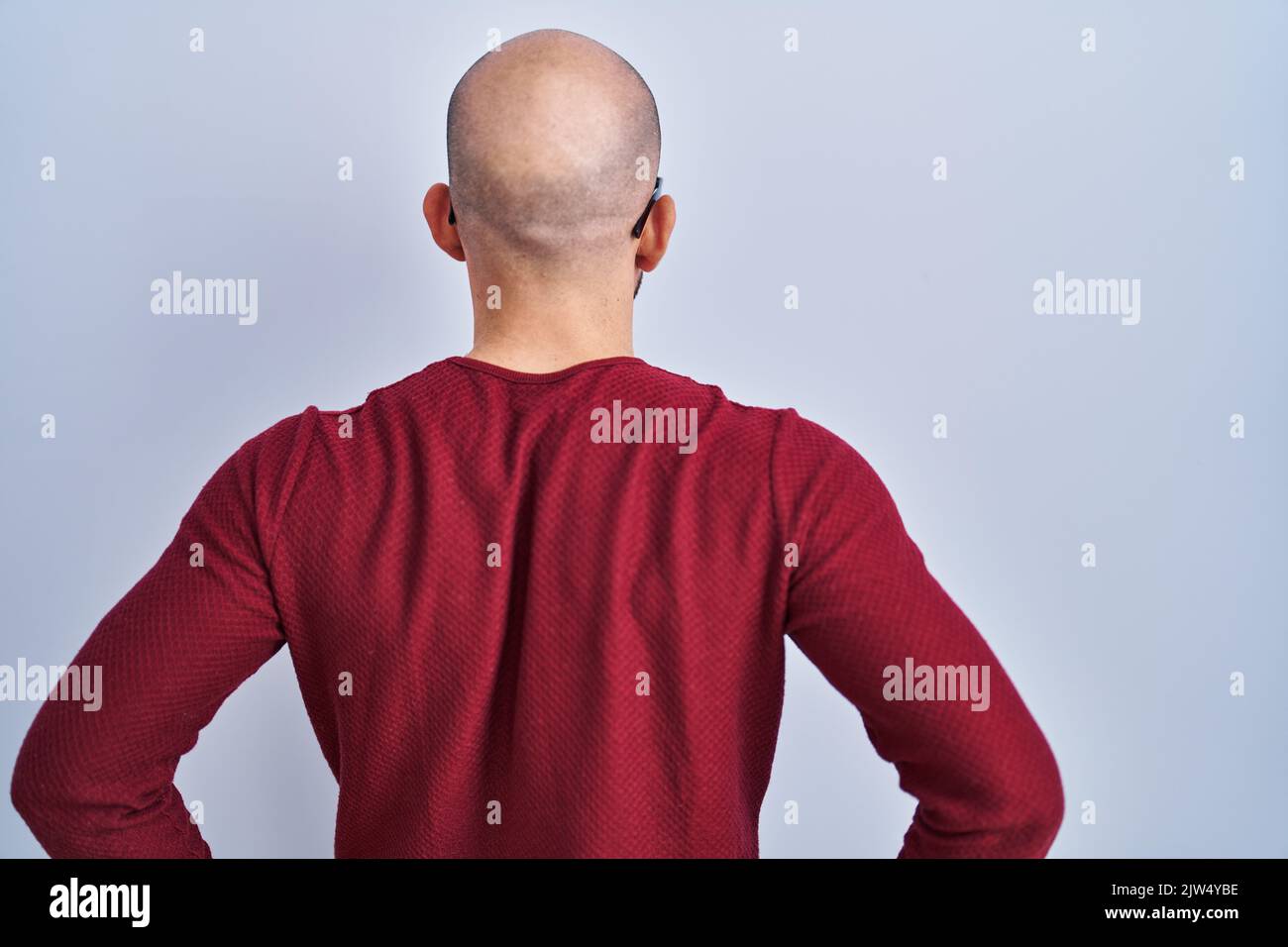 Young bald man with beard standing over white background wearing ...