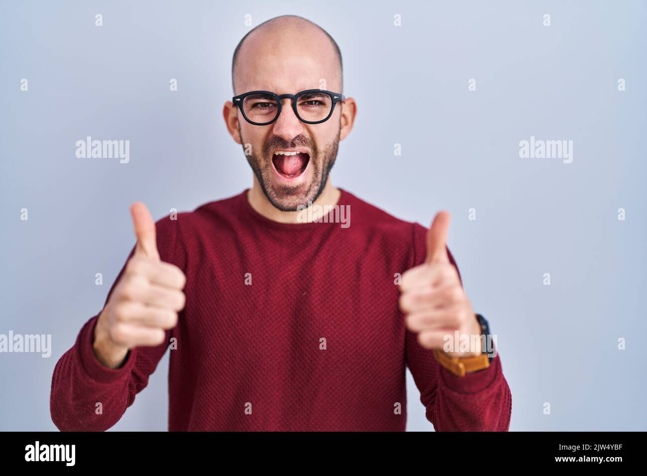 Young bald man with beard standing over white background wearing ...