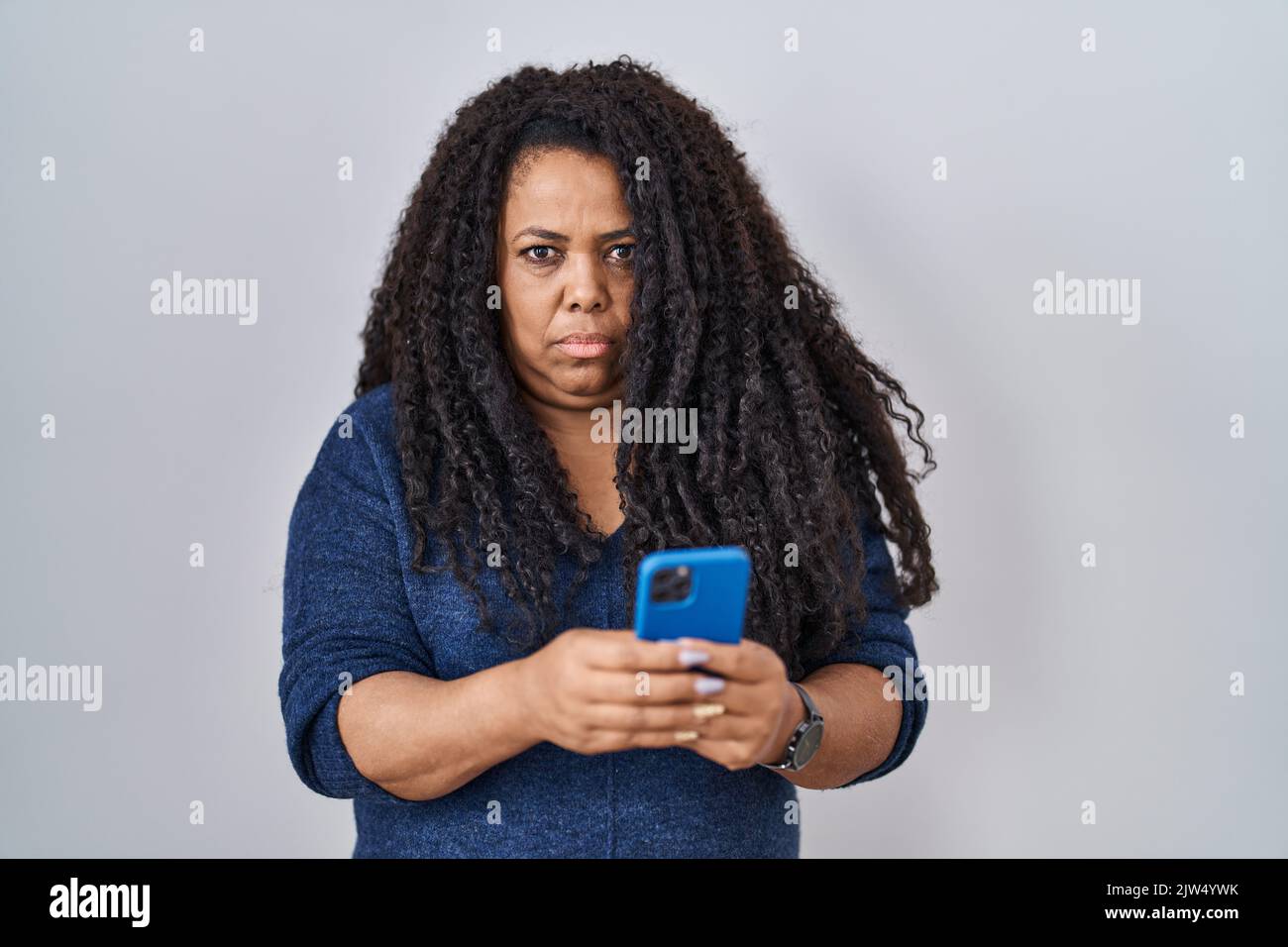 Plus size hispanic woman using smartphone typing message depressed and ...
