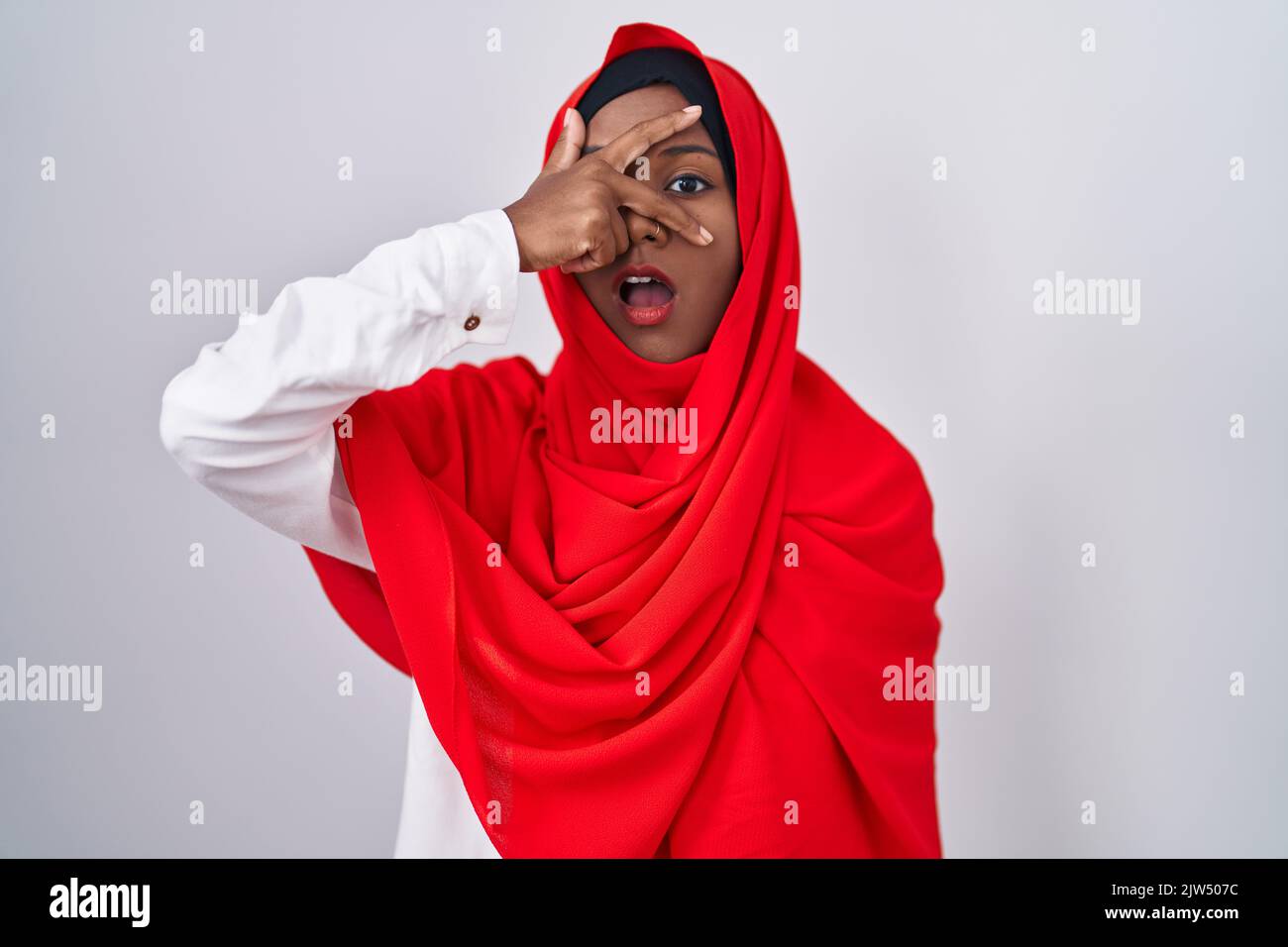 Young arab woman wearing traditional islamic hijab scarf peeking in ...