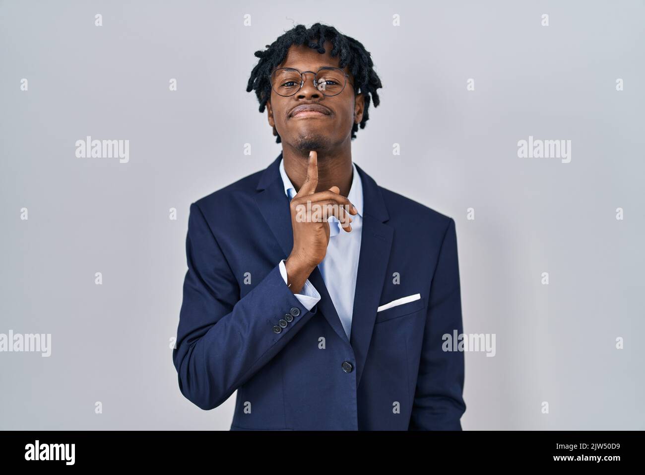 Young african man with dreadlocks wearing business jacket over white ...