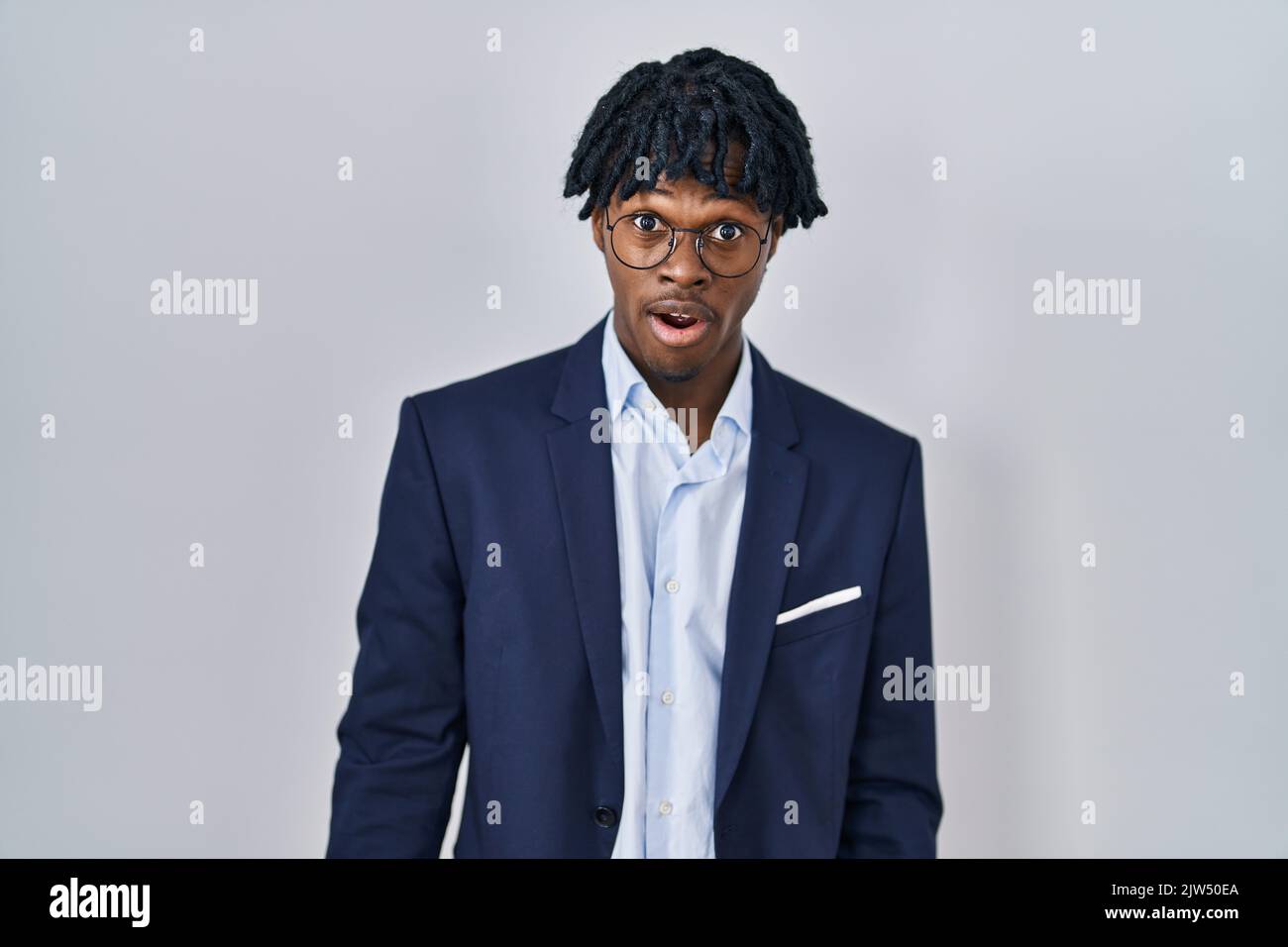 Young african man with dreadlocks wearing business jacket over white ...