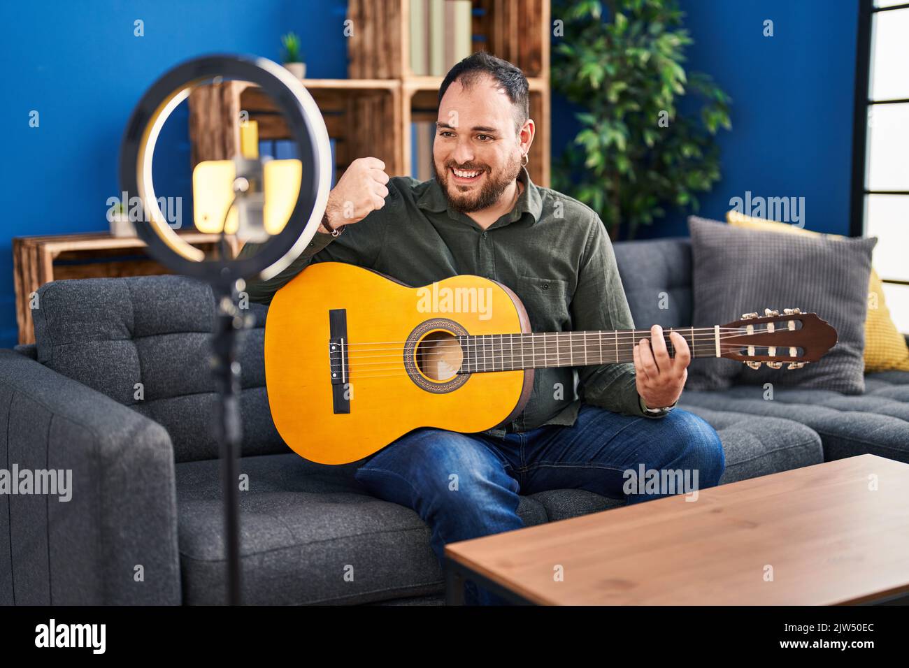 Plus size hispanic man with beard playing classic guitar at music ...