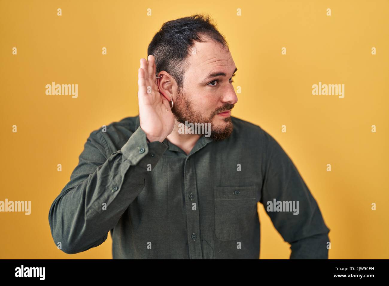 Plus size hispanic man with beard standing over yellow background ...