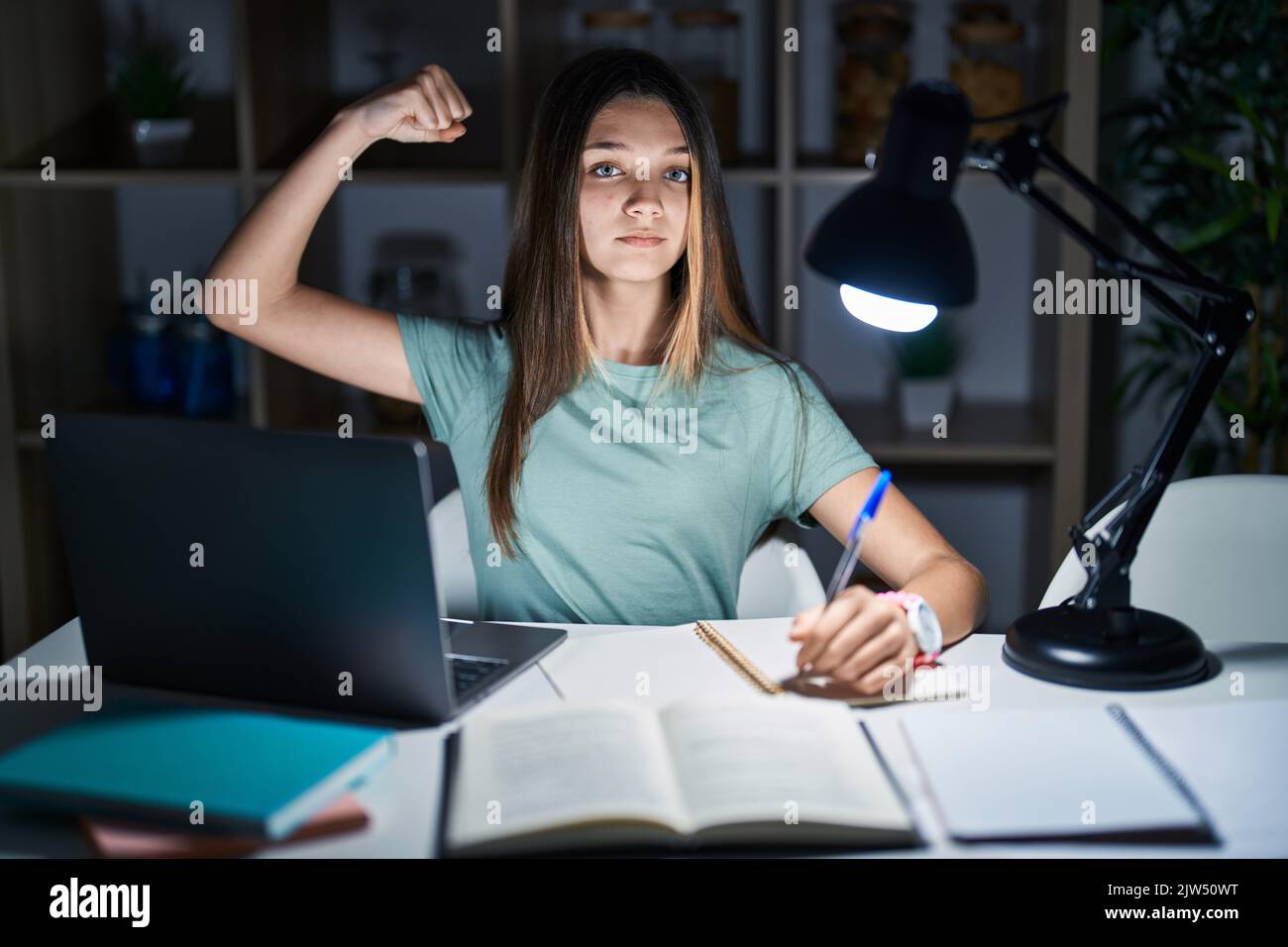 Teenager girl doing homework at home late at night strong person ...