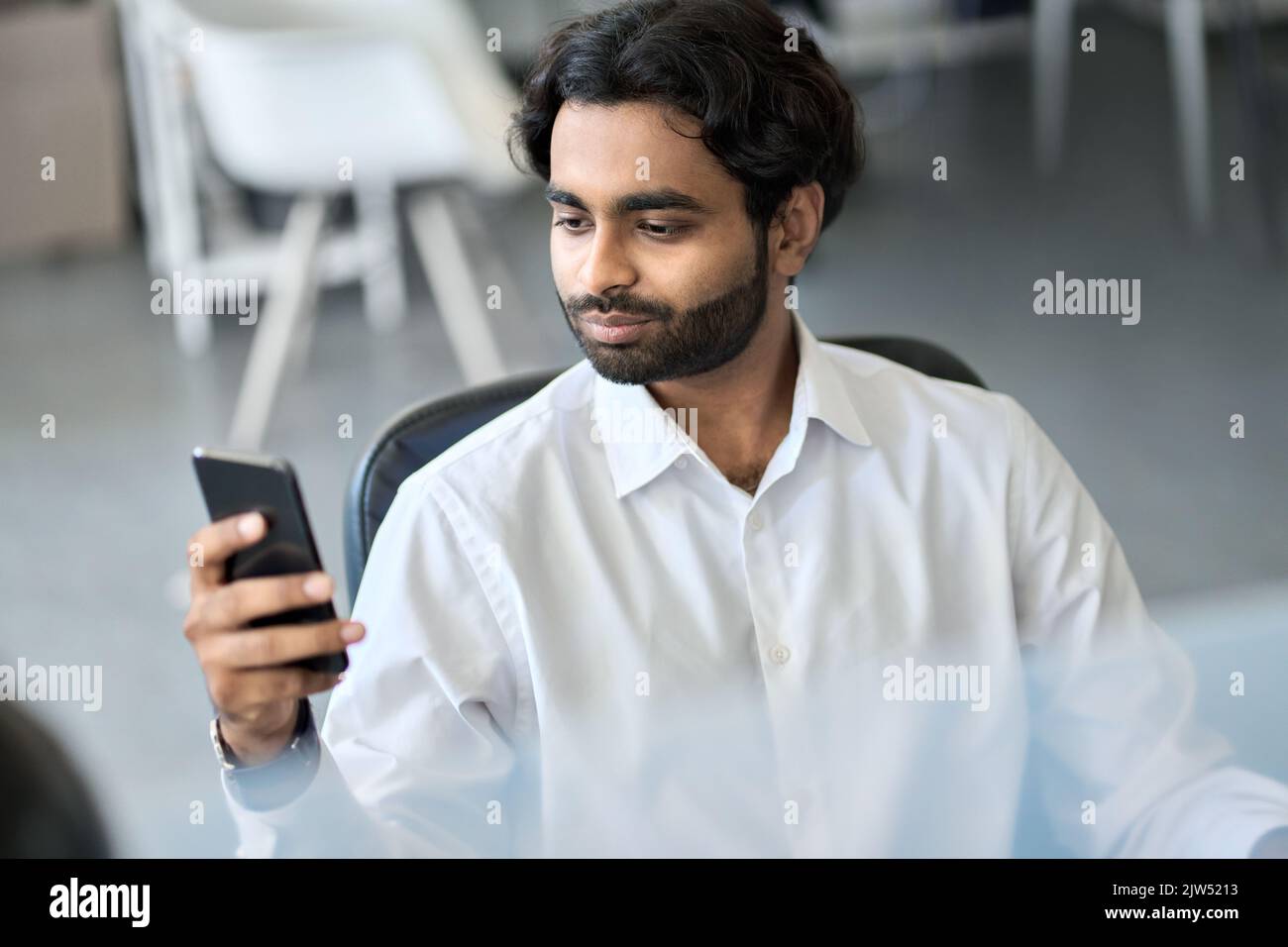 Young indian businessman using mobile phone apps at work in office ...