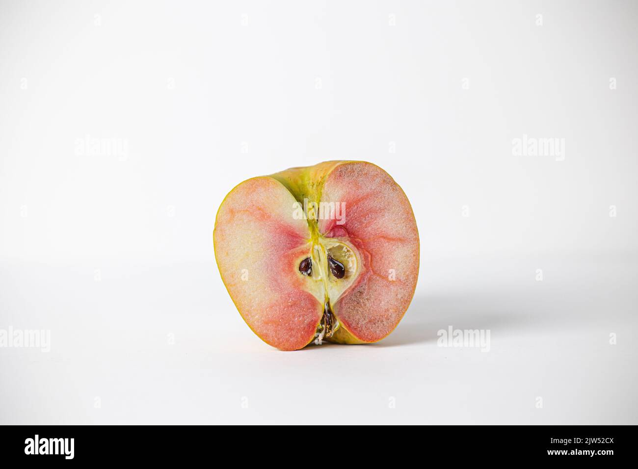 One half of a single lucy glo apple on a white background Stock Photo ...