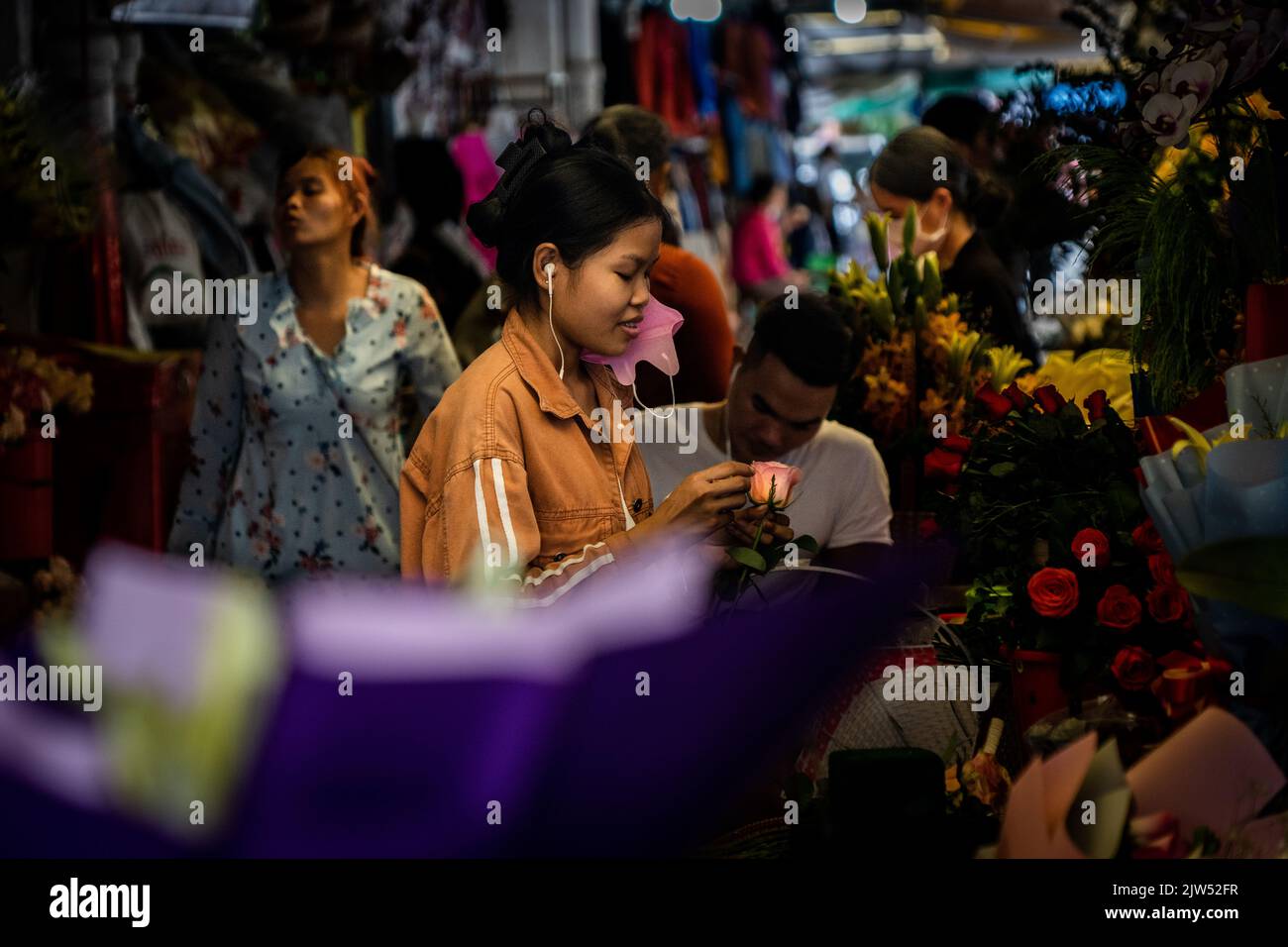 A street florist adds finishing touches to a single rose at Central ...