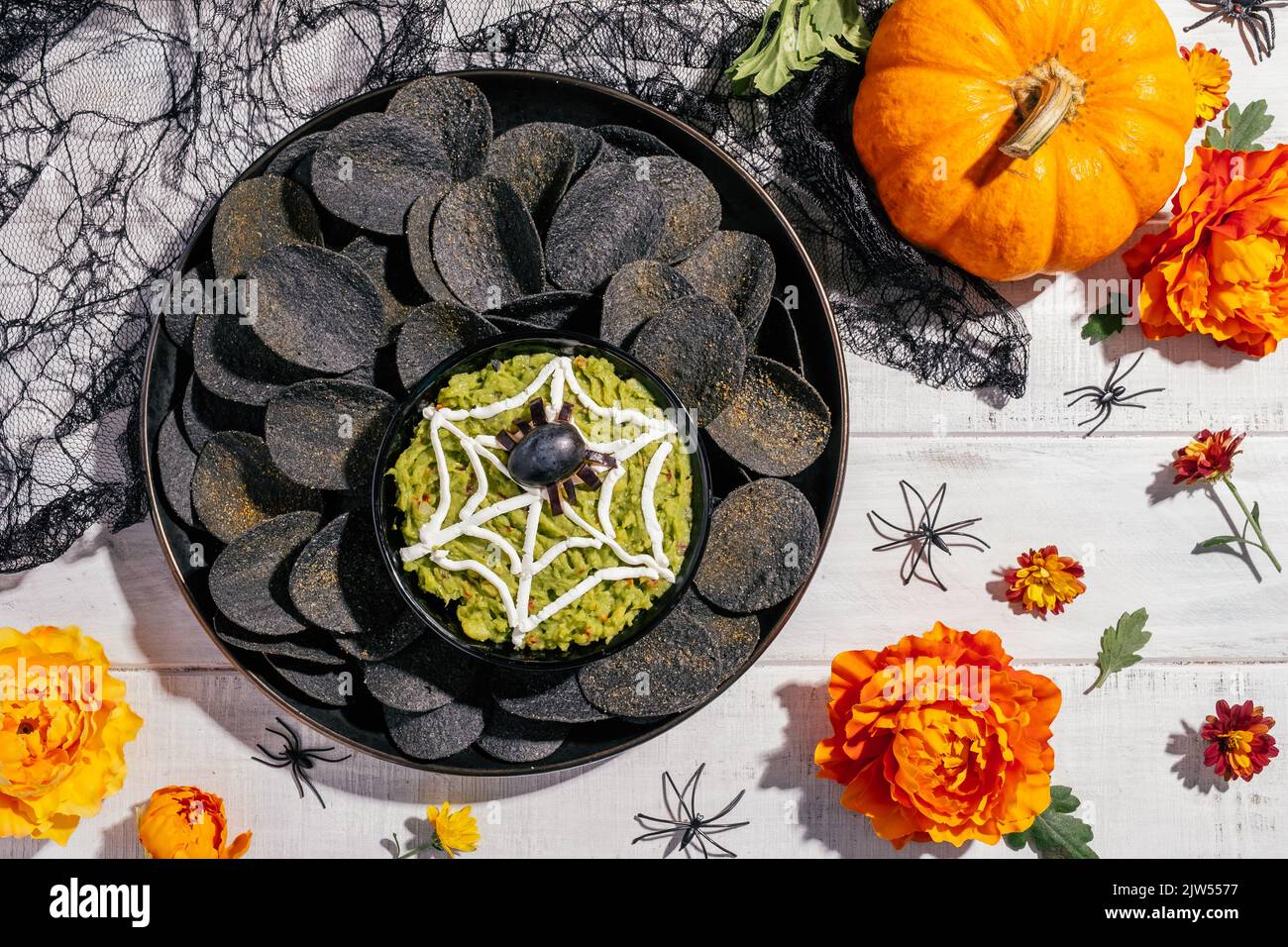 Spooky Halloween black potato chips with guacamole dip Stock Photo - Alamy