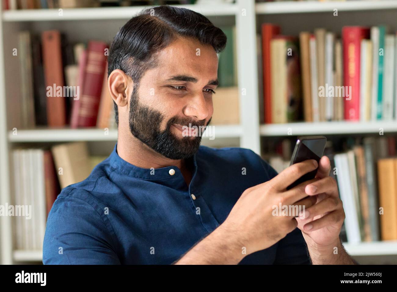 Indian business man holding smartphone using mobile phone at home or in ...