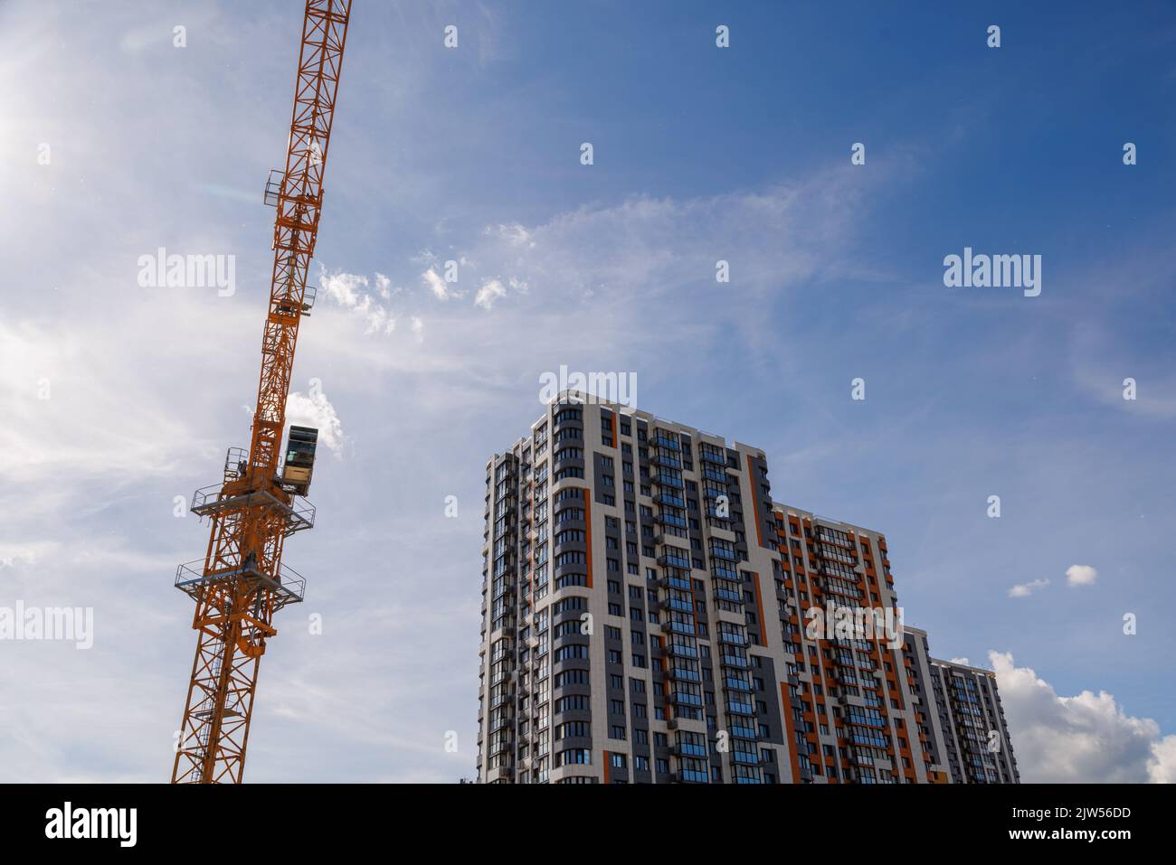 freshly built high rise apartment building near yellow crane on blue ...