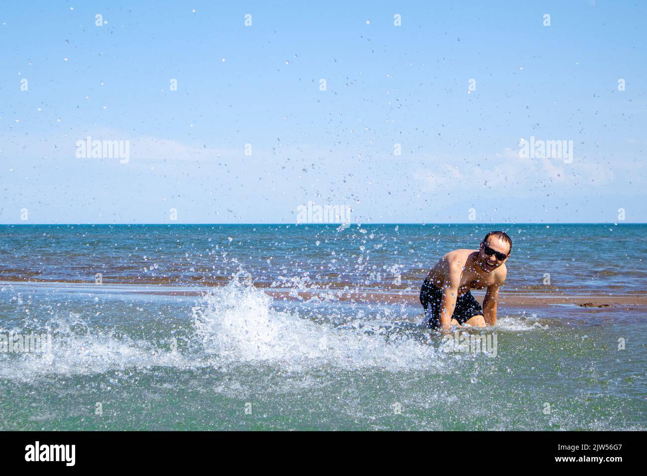 a man splashes on the water. funny guy in the water. holidays at the ...