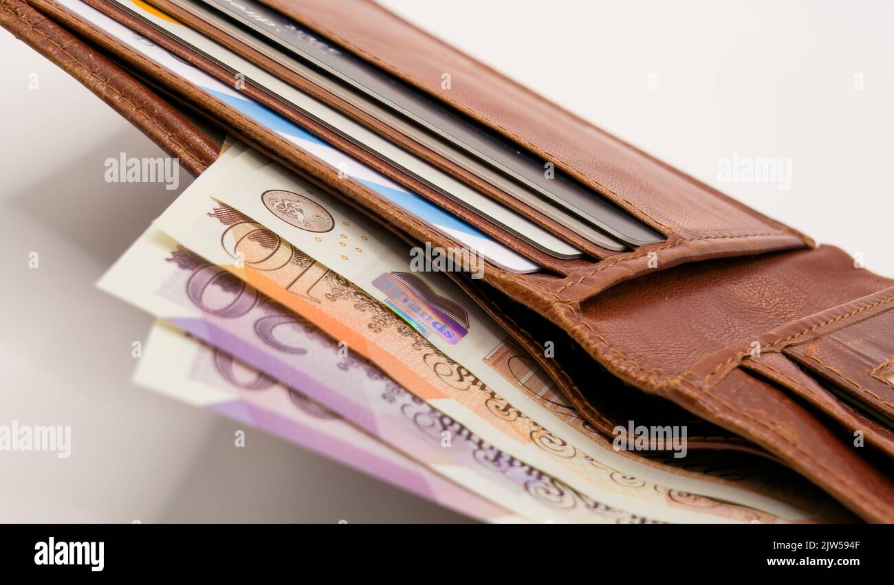 a light brown leather wallet with bank cards and a detailed close-up of ...