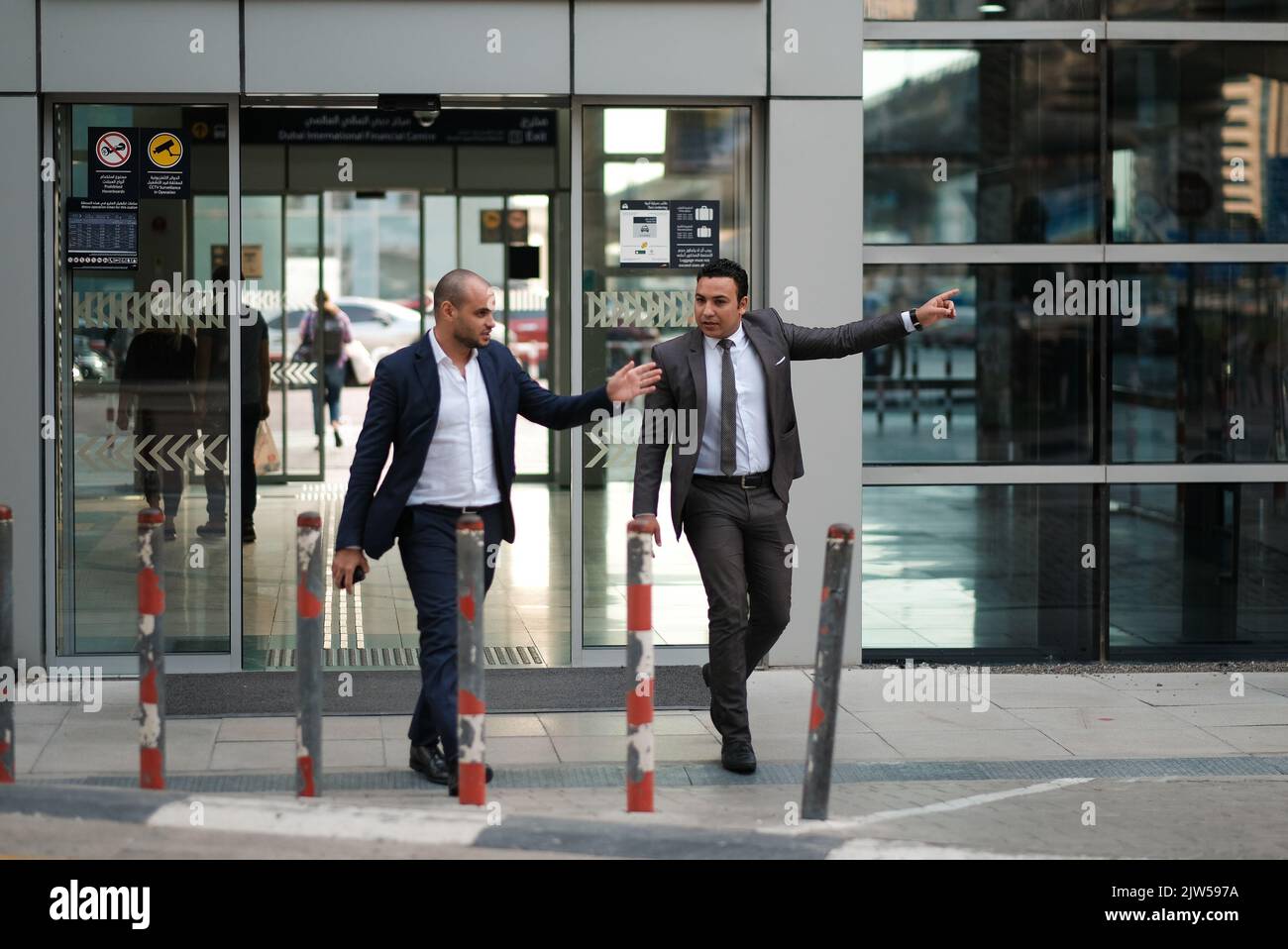 Two men in sharp suits walk out of a metro station in the Financial ...
