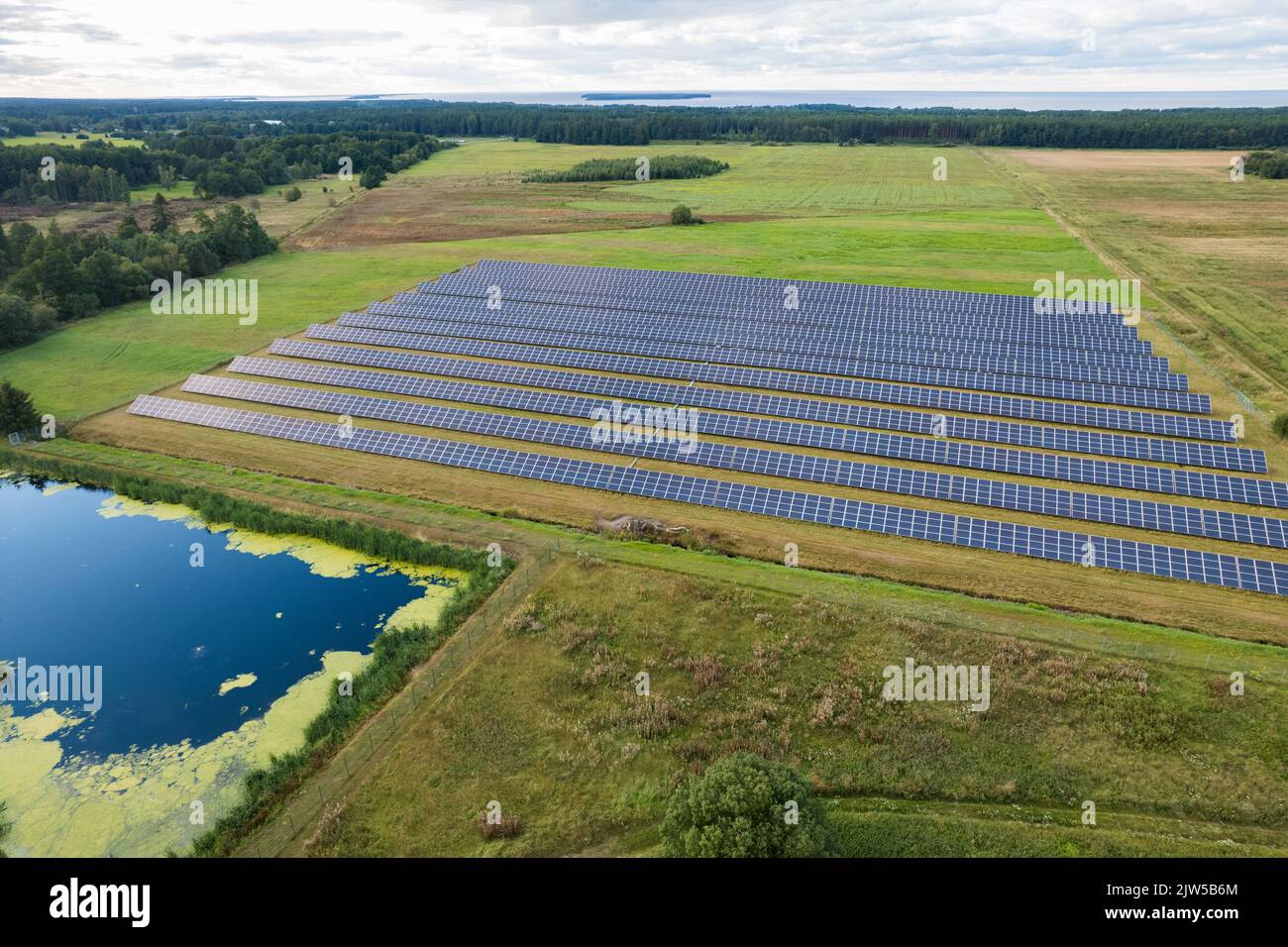 Aerial view of solar panels on a green grass field. Alternative energy ...