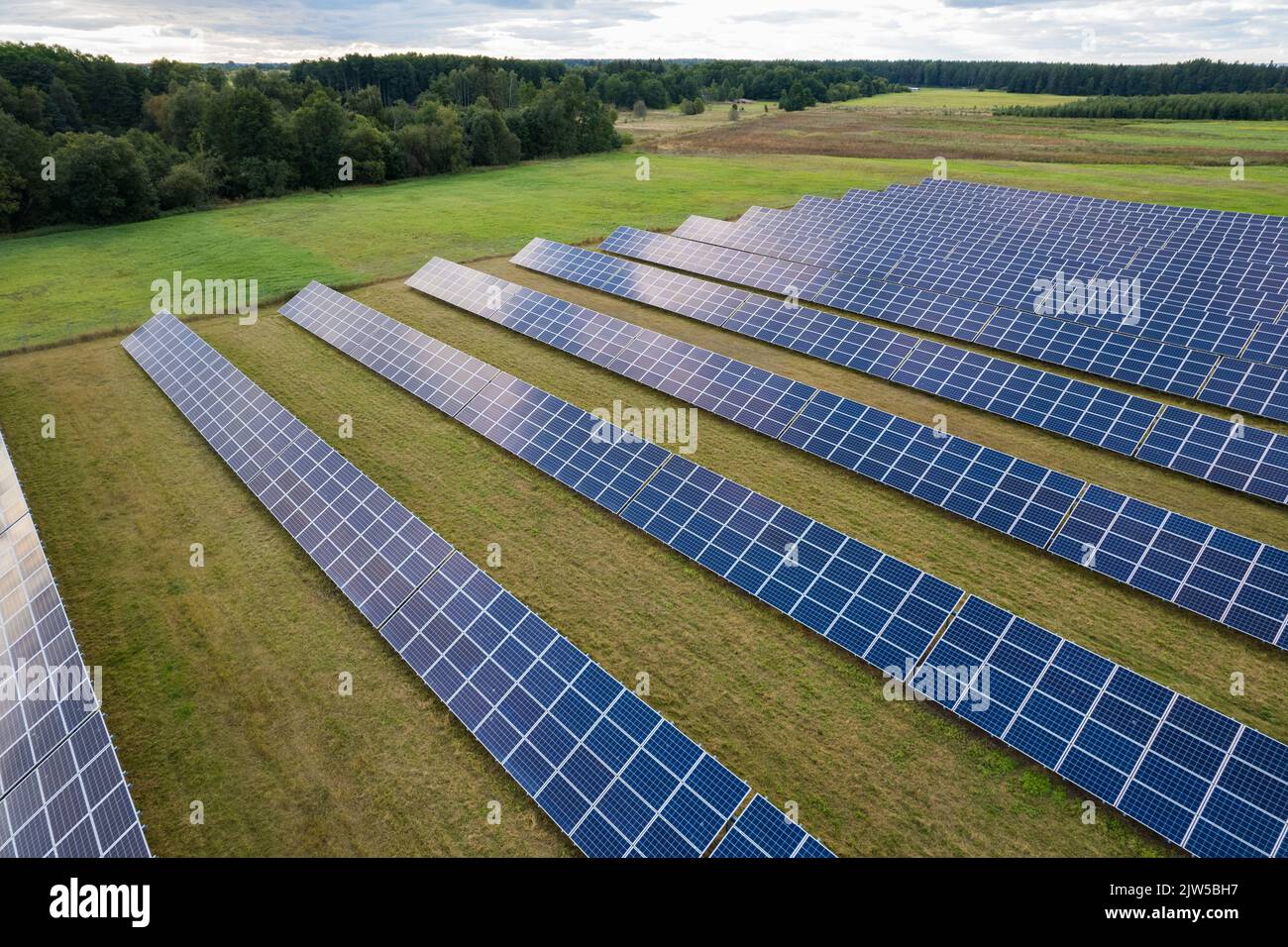 Aerial view of solar panels on a green grass field. Alternative energy ...